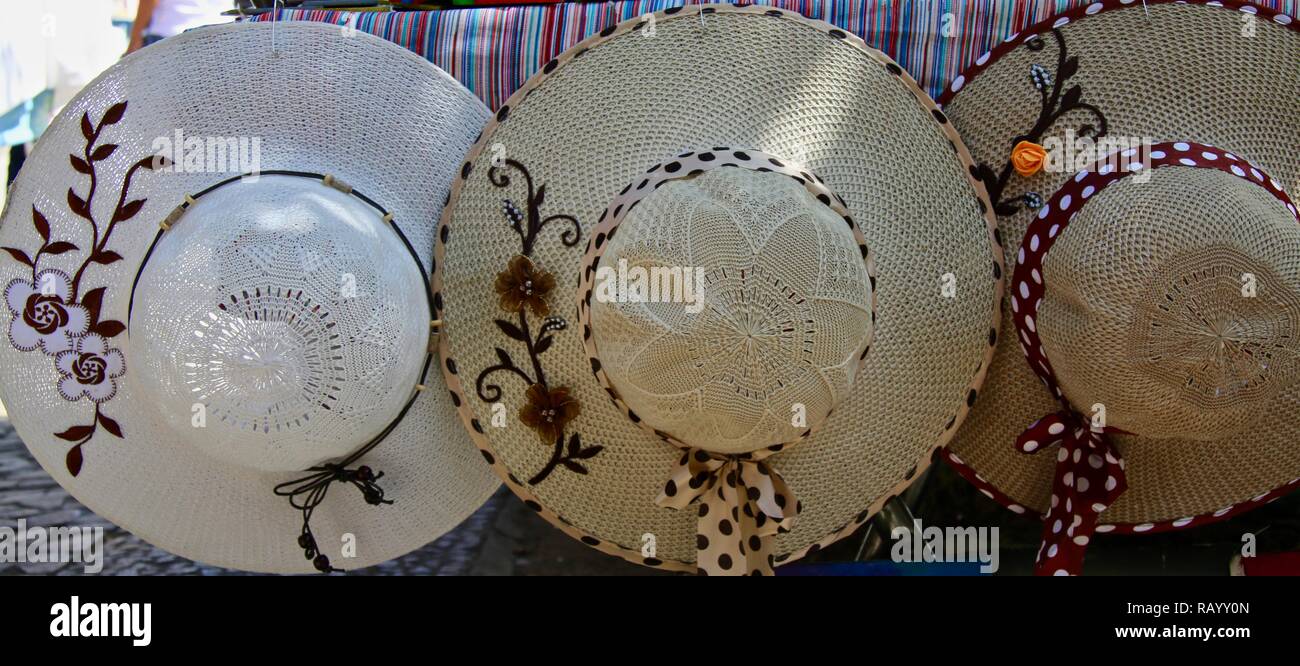 Three elegant embroidered straw sun hats hanging Stock Photo - Alamy