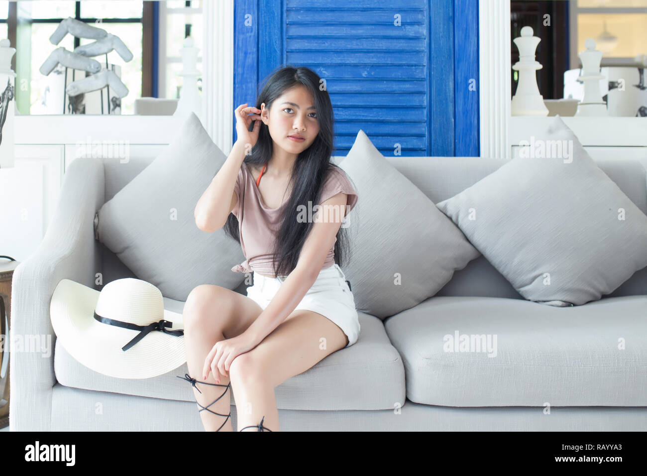 Relaxing woman sitting comfortable in sofa lounge chair smiling happily ...