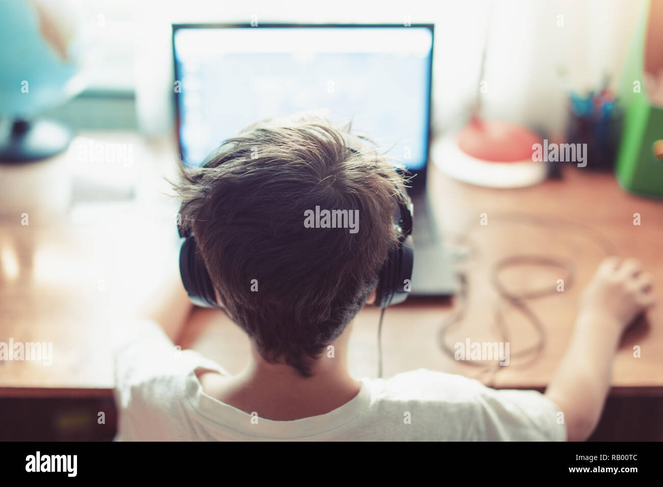 Little dependent gamer kid playing on laptop indoors Stock Photo - Alamy