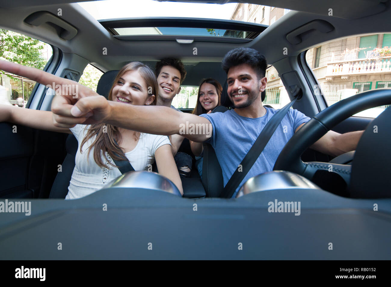 Happy young woman car pointing finger hi-res stock photography and ...