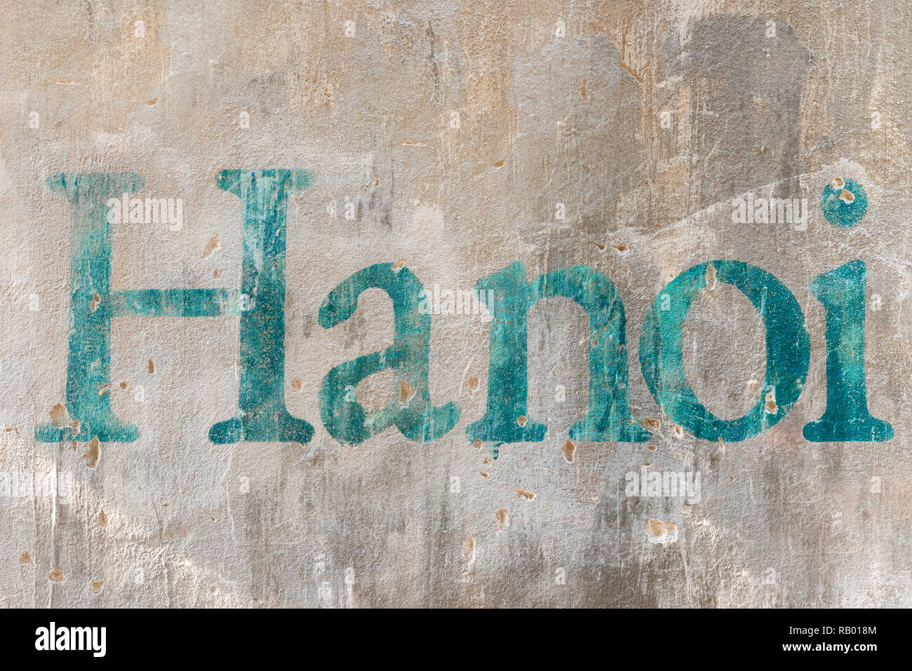Hanoi city name painted in green paint on a wall with stencilled ...