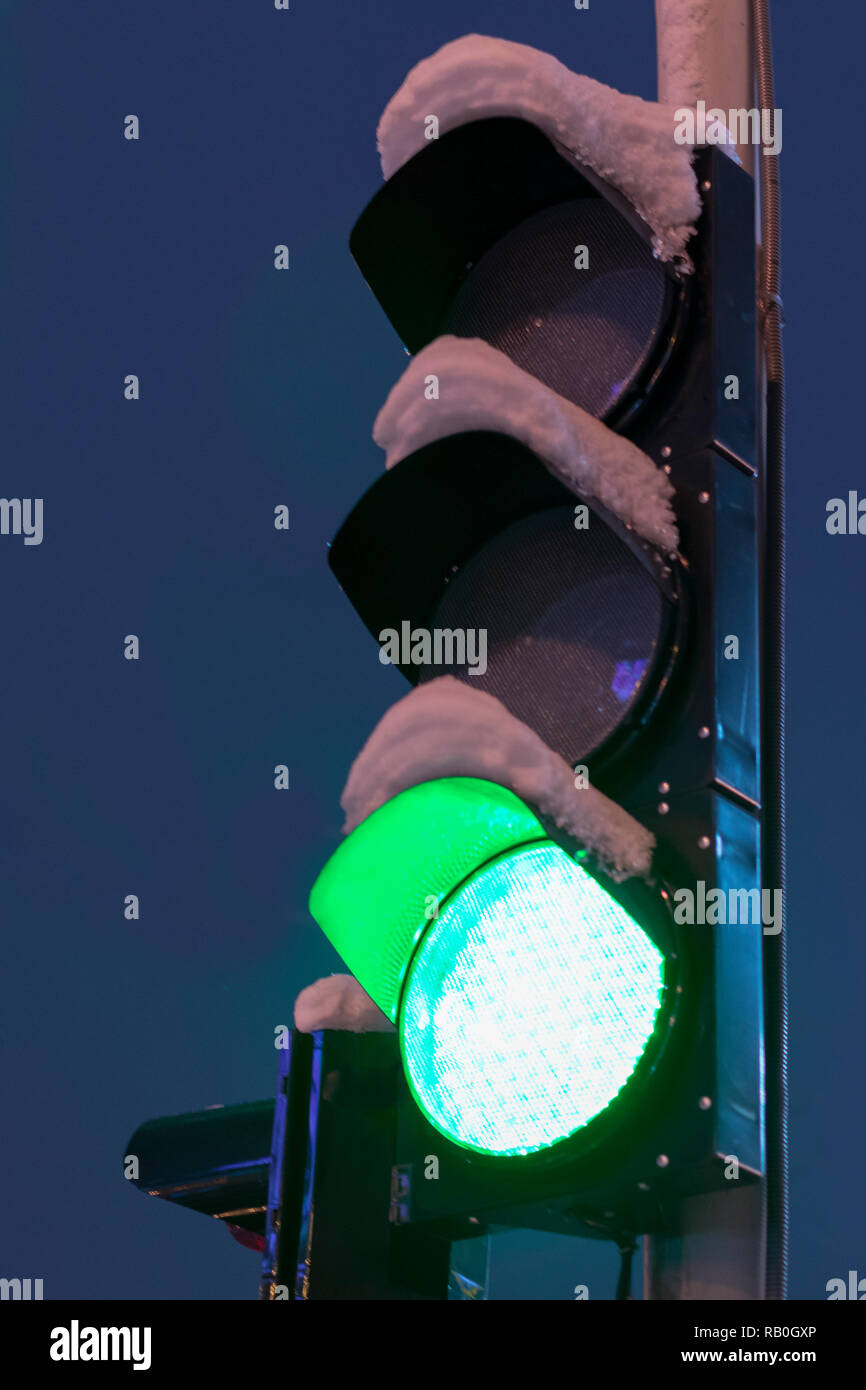 Green light traffic light on a dark background. A closeup photo of ...