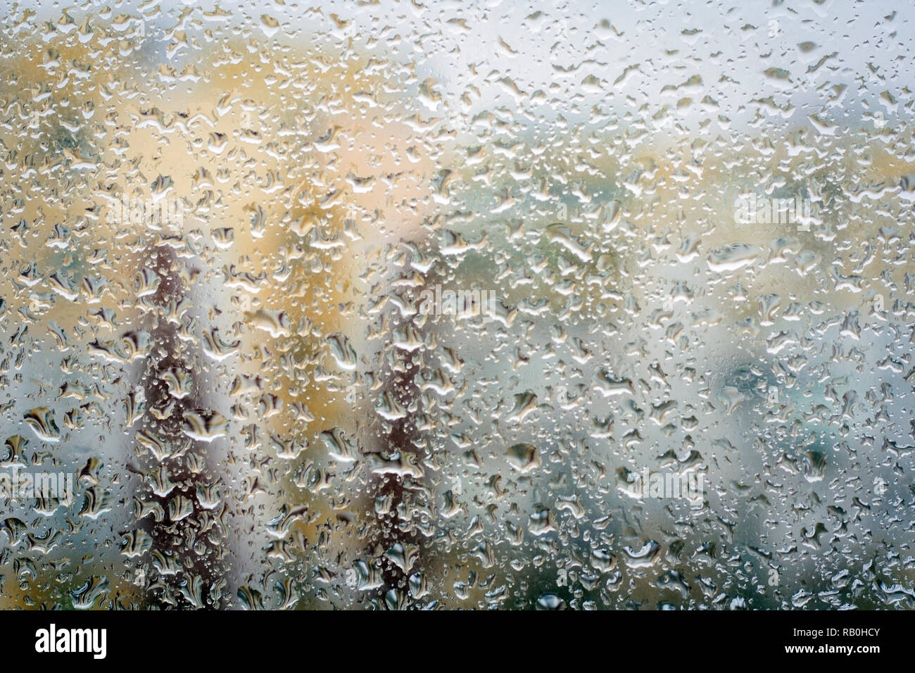 Raindrops on glass, window background view of buildings out of focus ...