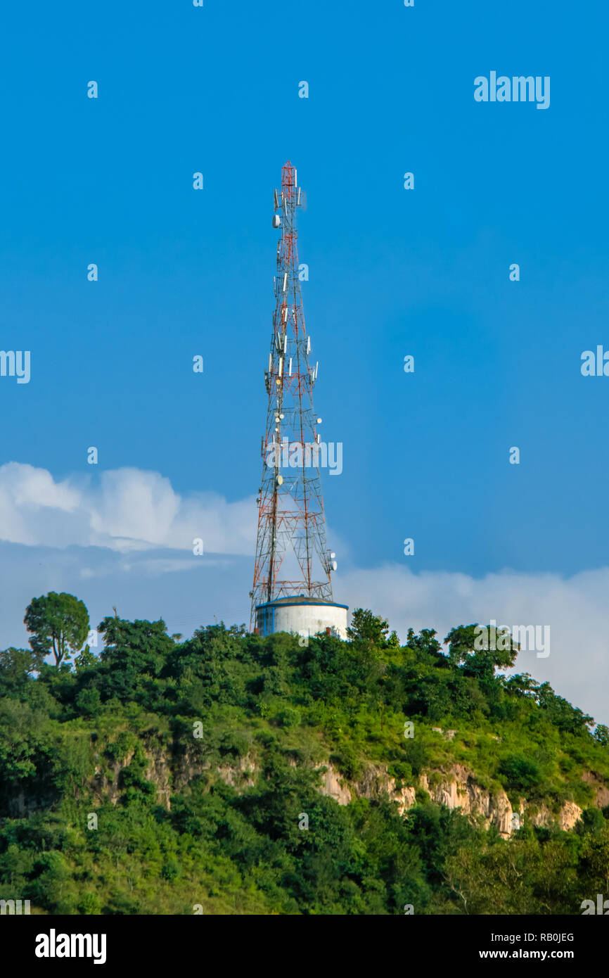 Red and silver color cell phone or mobile tower installed on top of the ...