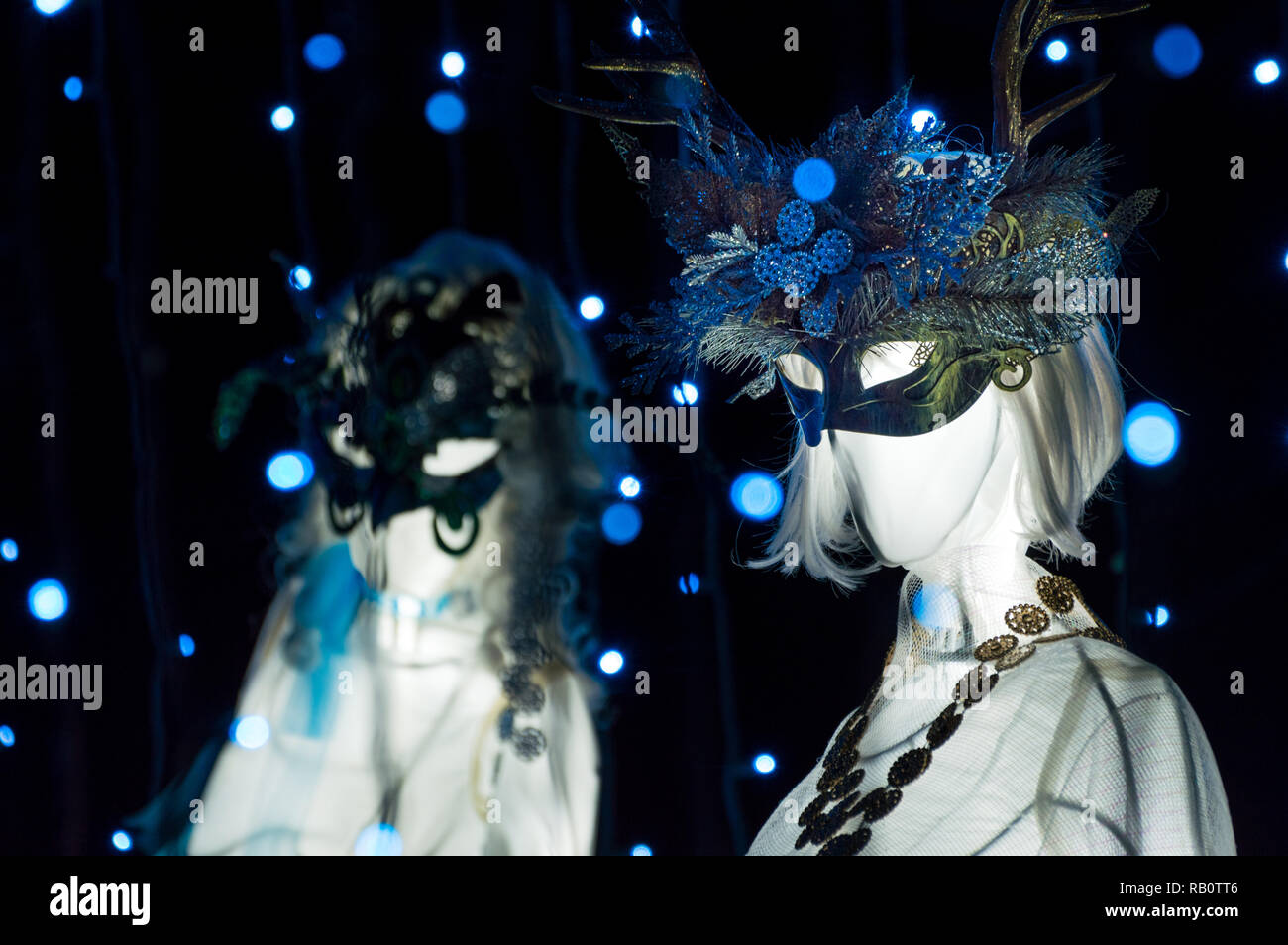 Ornately masked white glowing statues among blue fairy lights from the ...