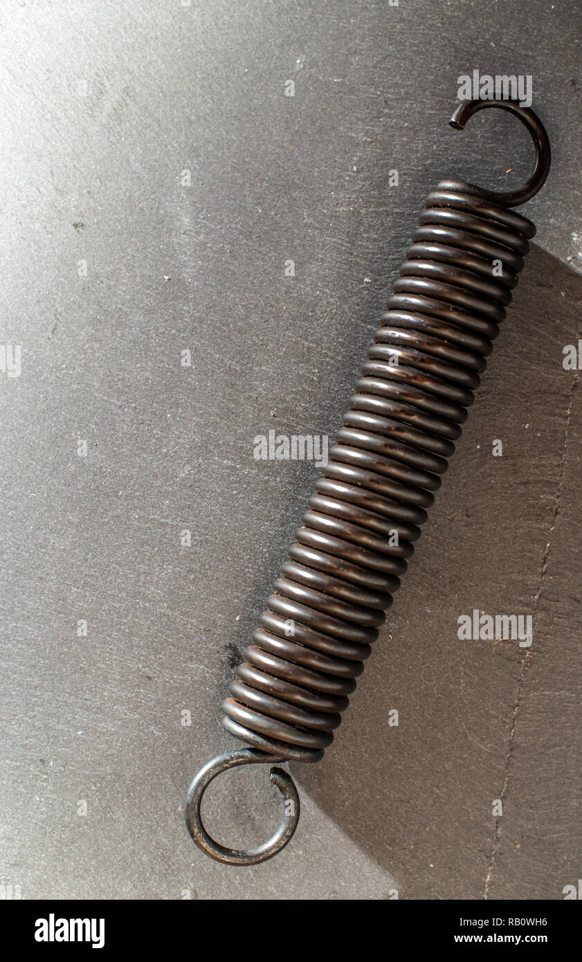 Metal spring on dark background. Concept for elasticity, force and ...