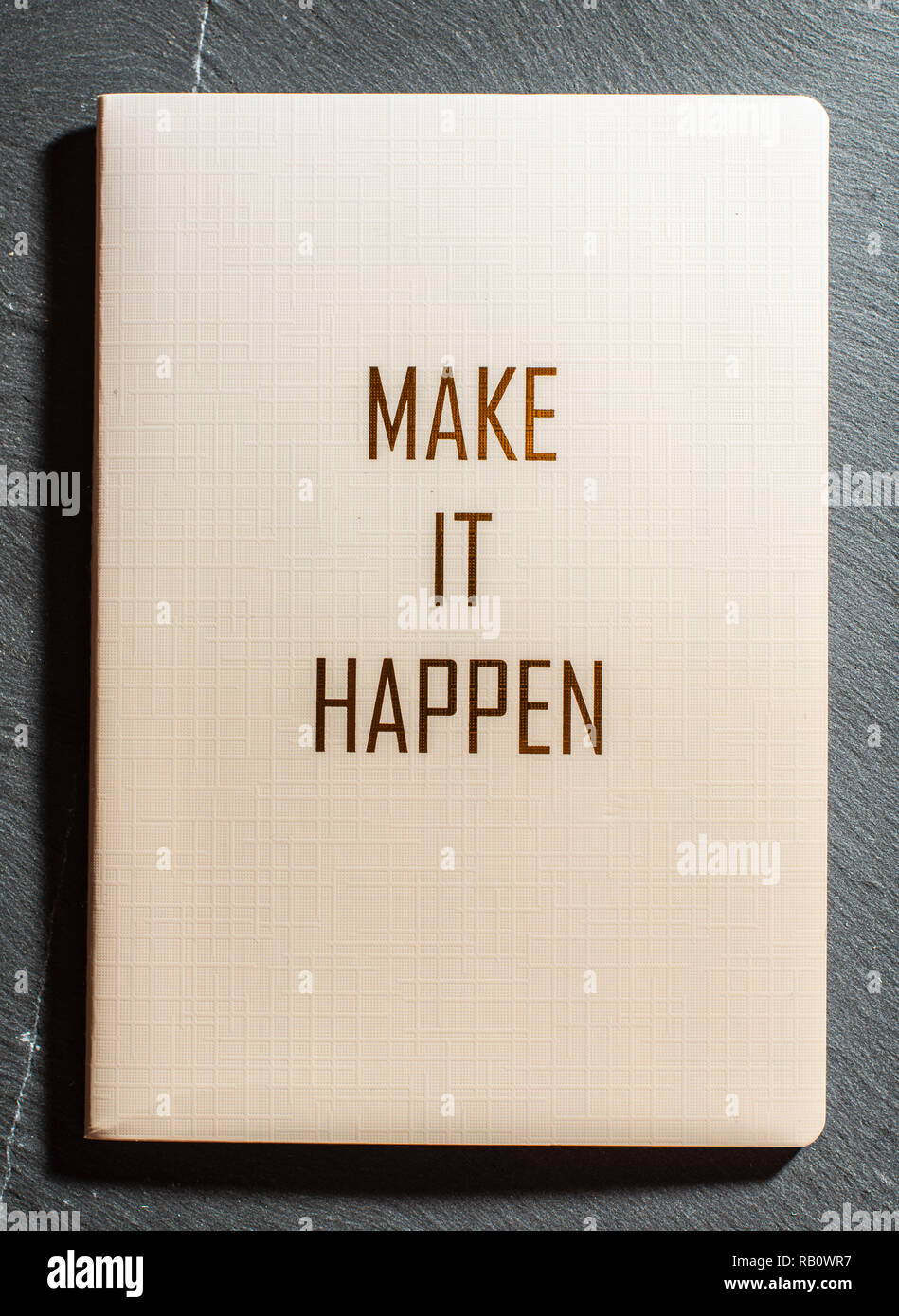 Make It Happen text on notebook on dark background. Concept for doing ...