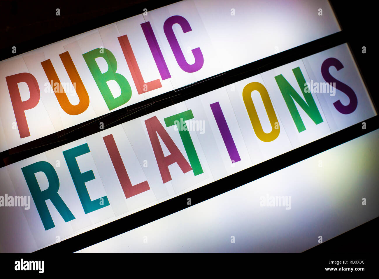 Public Relations text on backlight board. Colored Characters on white ...