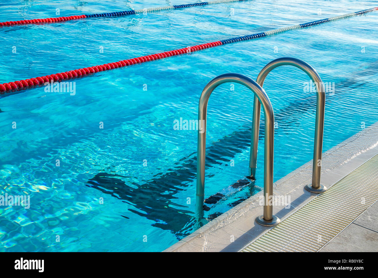 Swimming pool, ladders and steam from the hot water in the morning spa ...