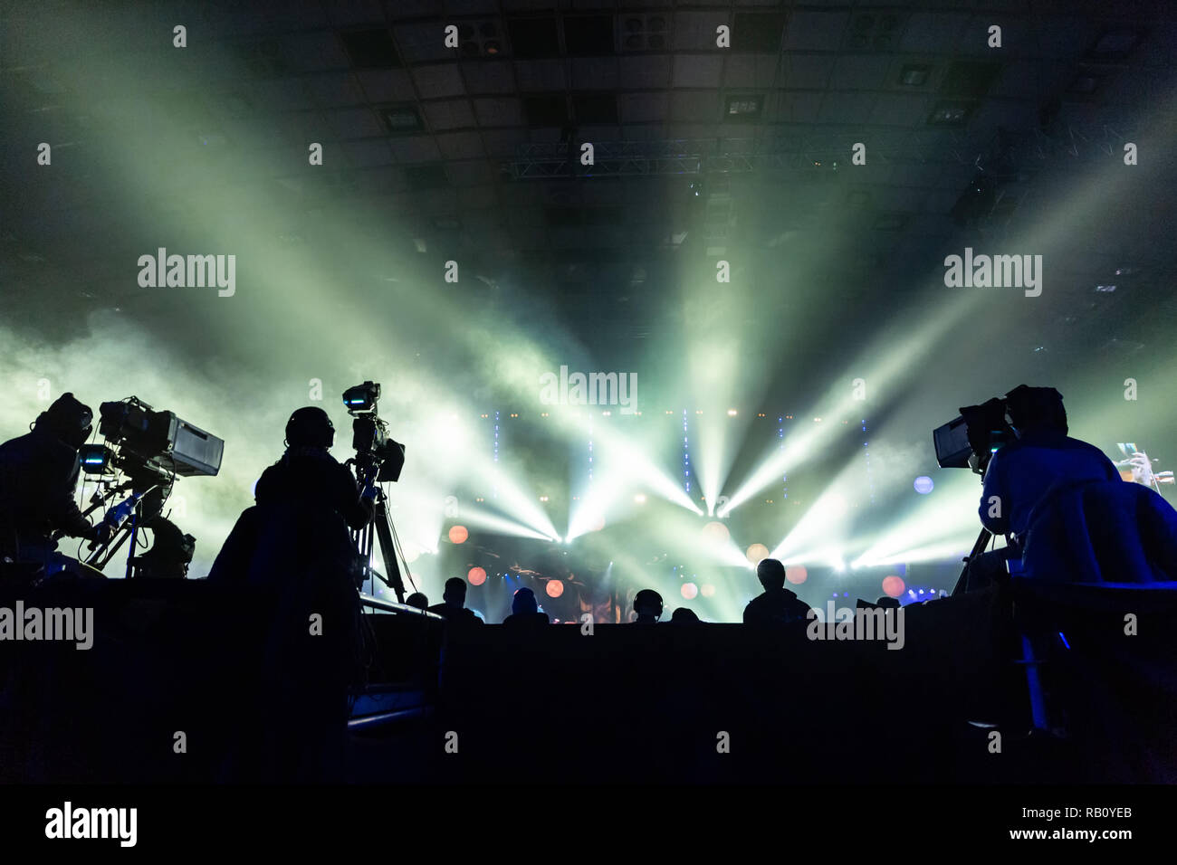 Silhouette of a group of cameramen broadcasting an event. Workers are ...