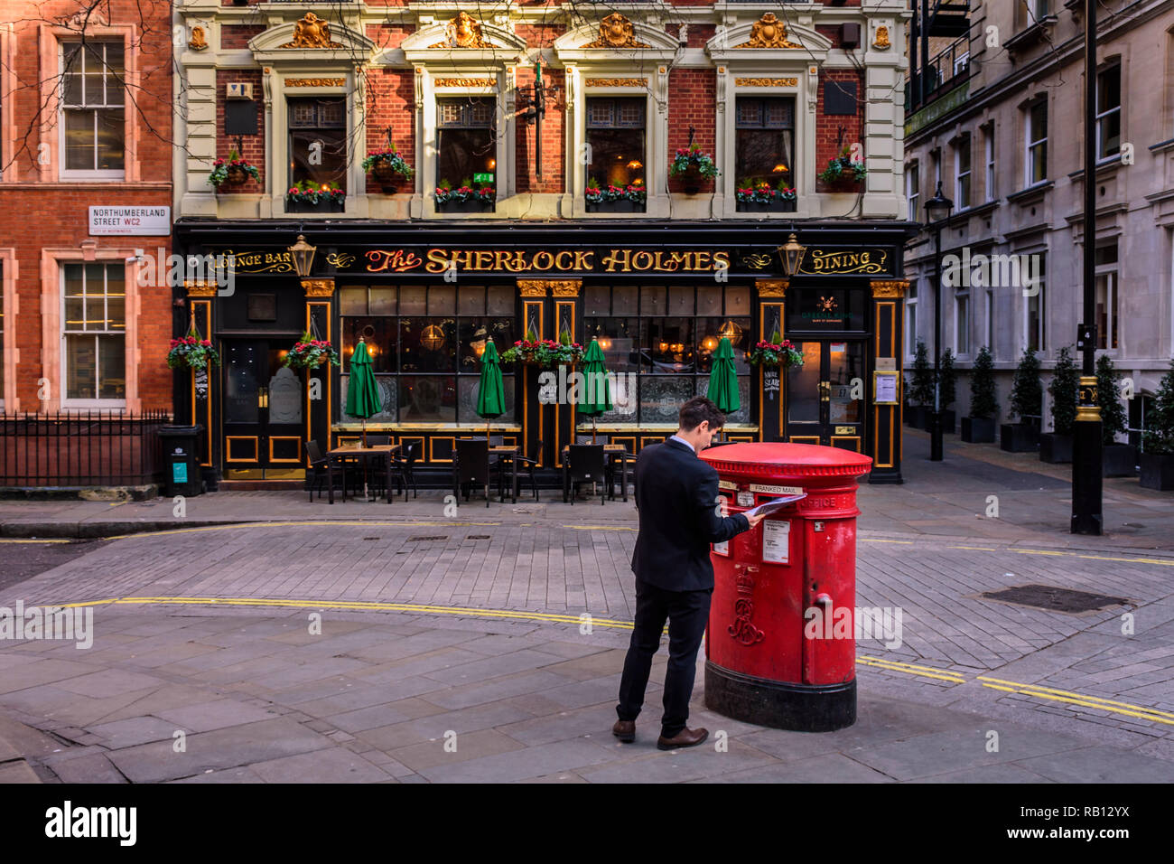 A young man stand in front of red post box in London Stock Photo - Alamy