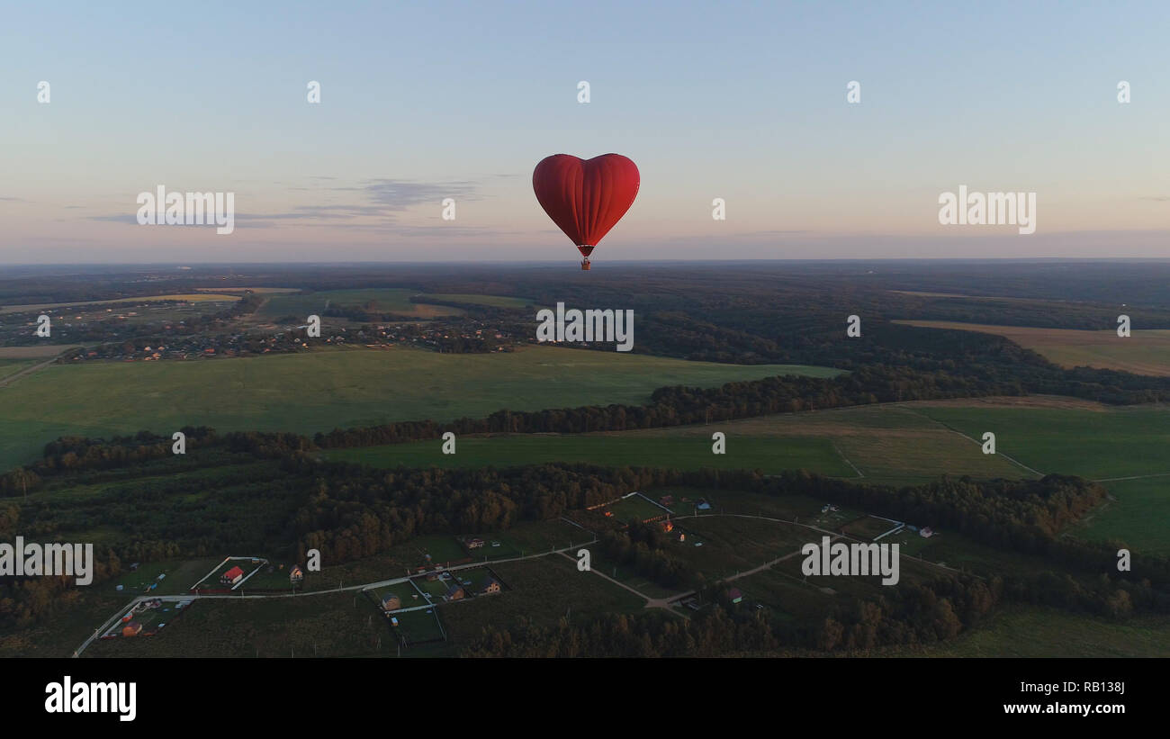 Aerial view Hot air balloon shape heart in sky over field in ...