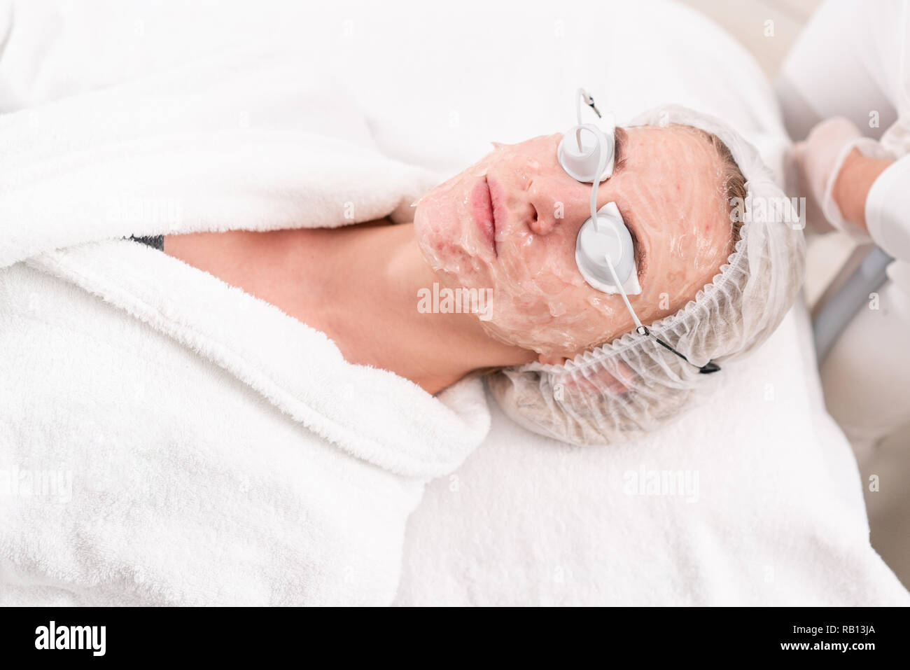 Portrait of a young woman patient. Anti acne phototherapy with ...