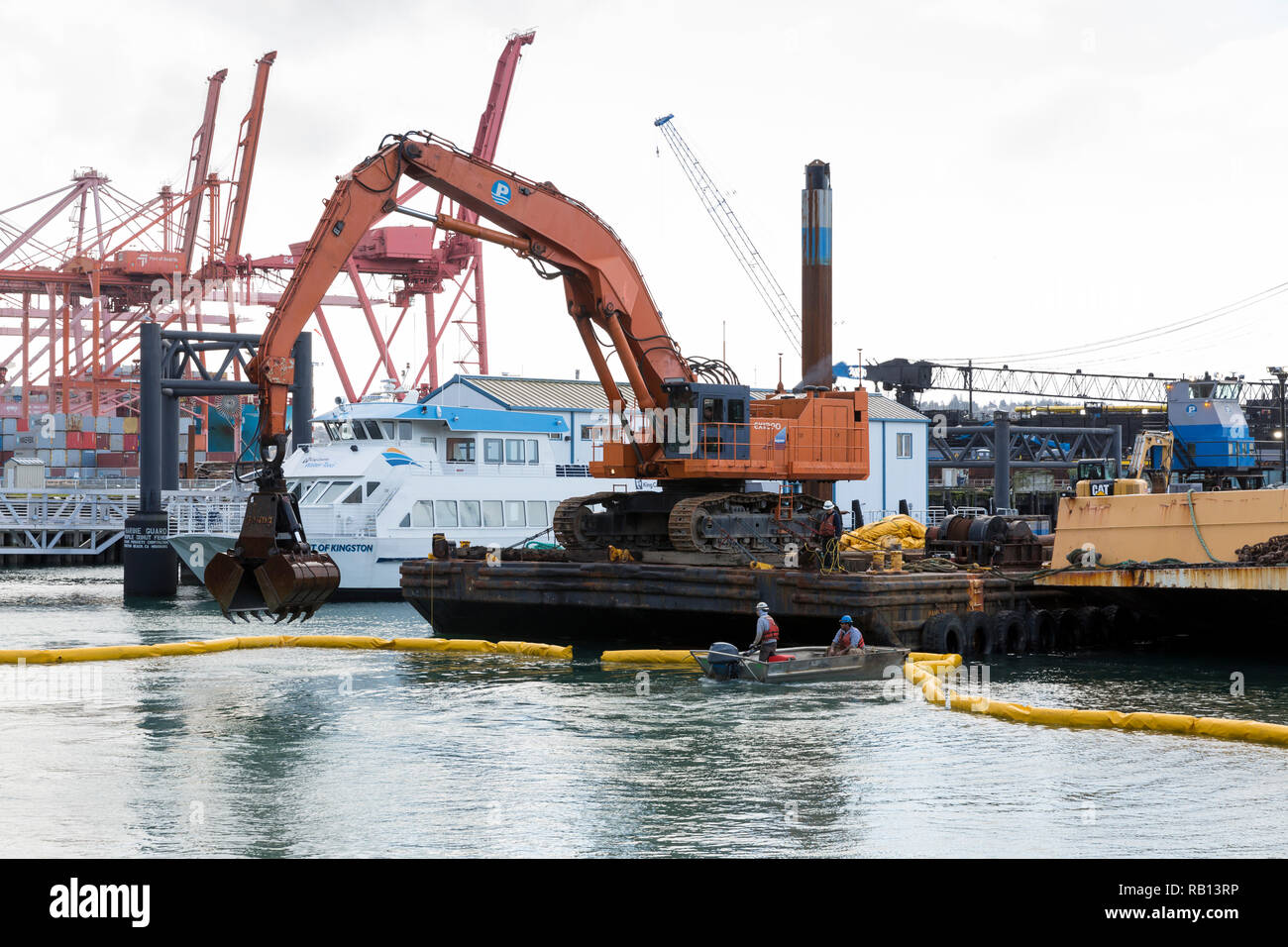 Seattle, Washington: An excavator loads rock from a barge to the ...