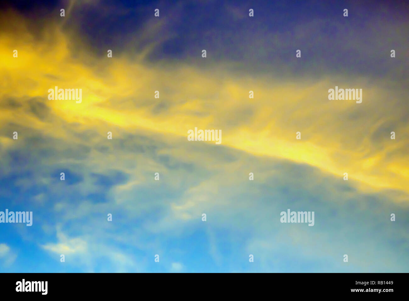 Fluffy yellow clouds in the blue sky Stock Photo - Alamy