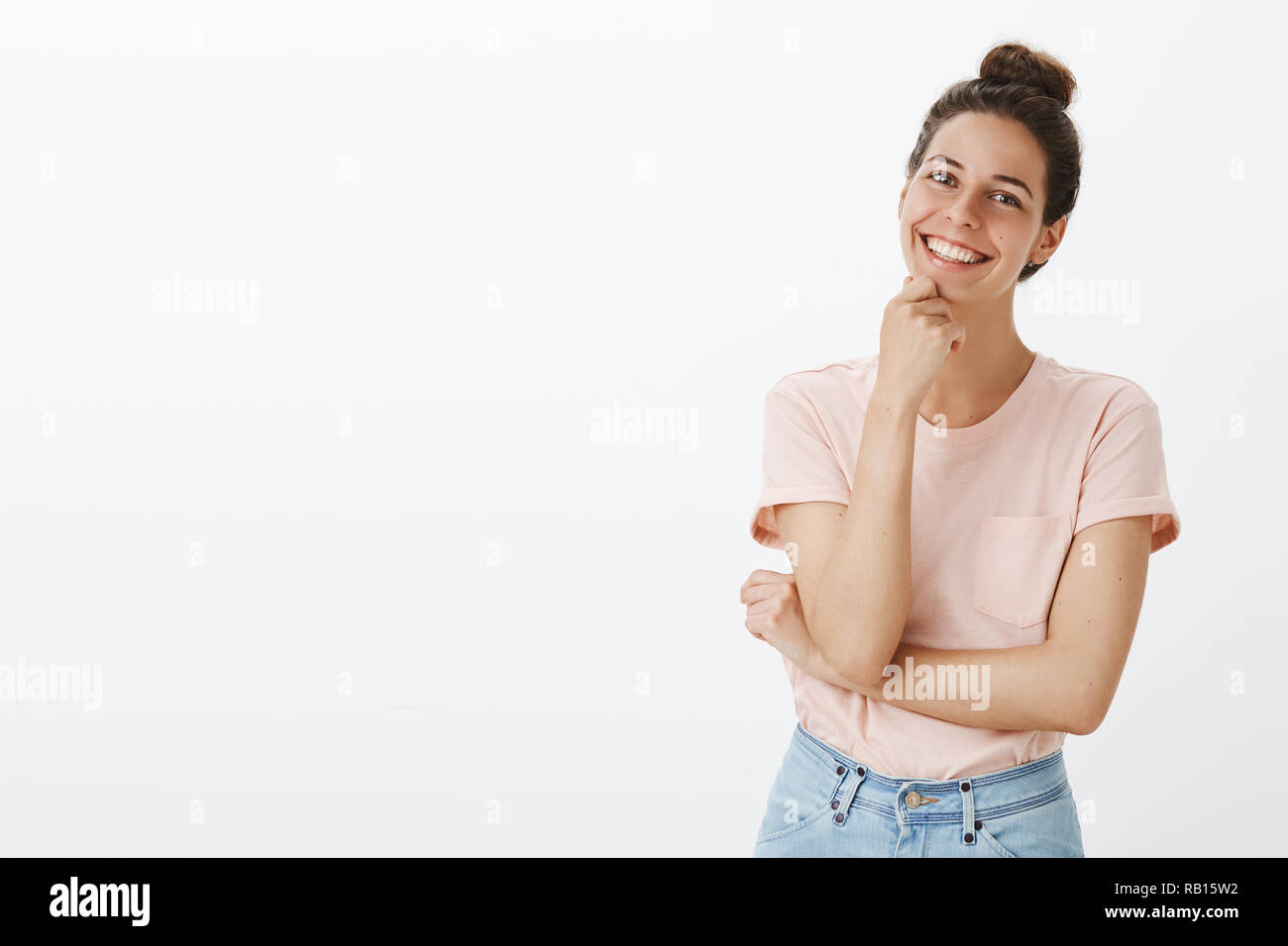 Beautiful carefree caucasian woman tilting head holding hand on jaw ...