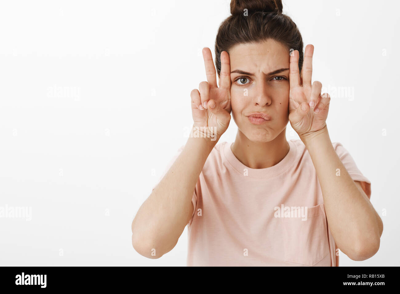 Girl making faces as feeling gloomy trying cheer up fooling around ...