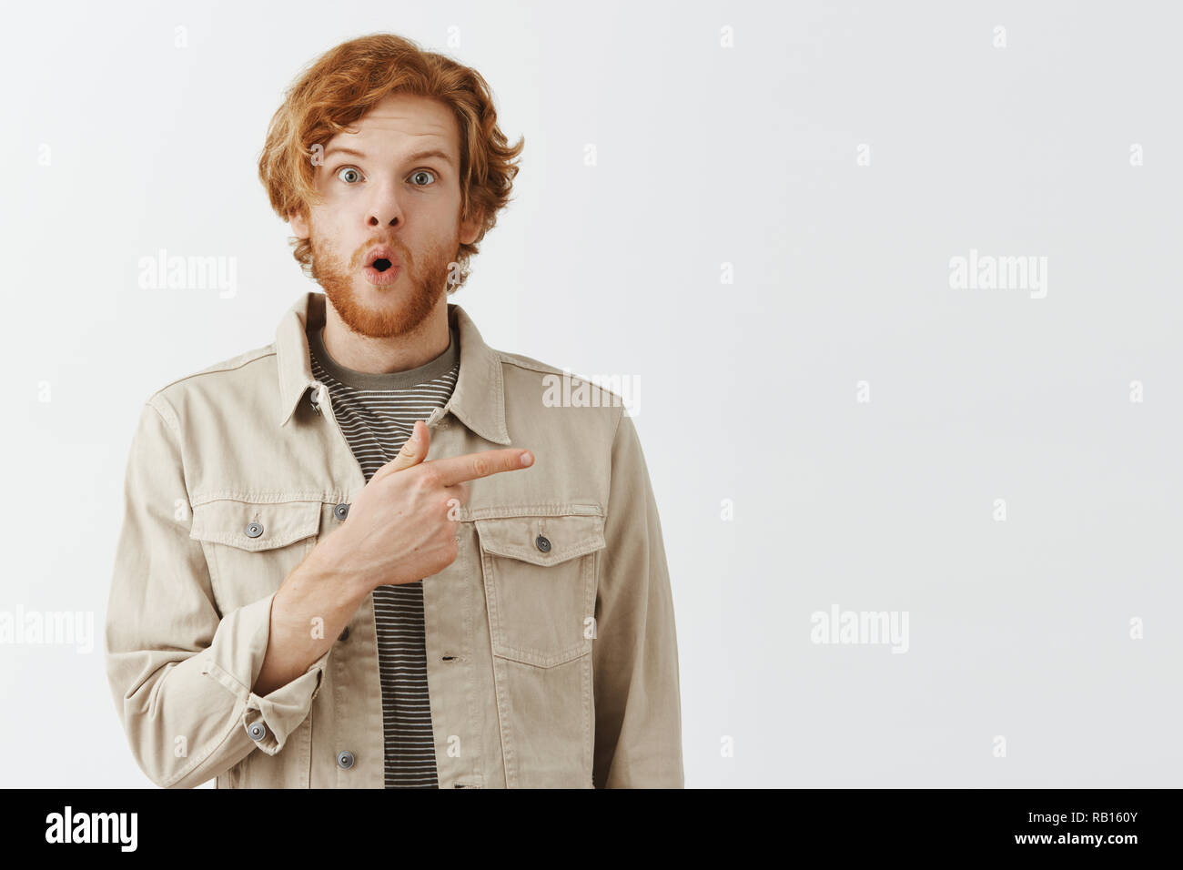 Waist Up Shot Of Curious And Intrigued Attractive Emotive Redhead Male