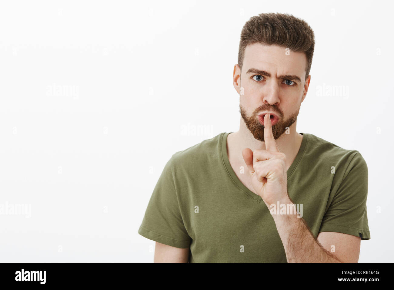 Angry displeased young man with beard frowning and looking irritated as ...