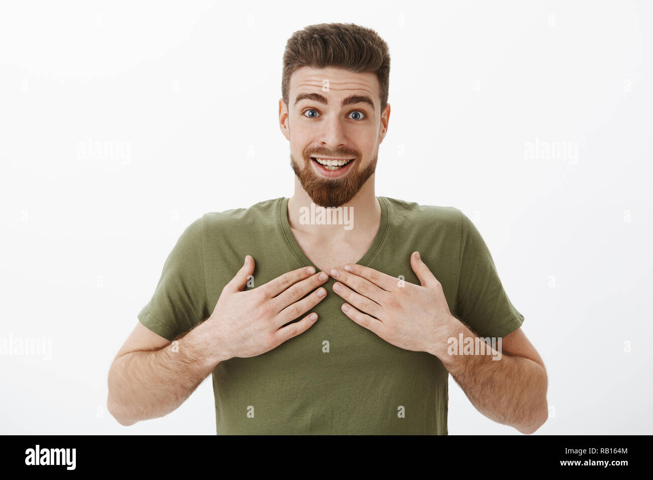 Surprised grateful and amazed happy young bearded guy in olive t-shirt ...
