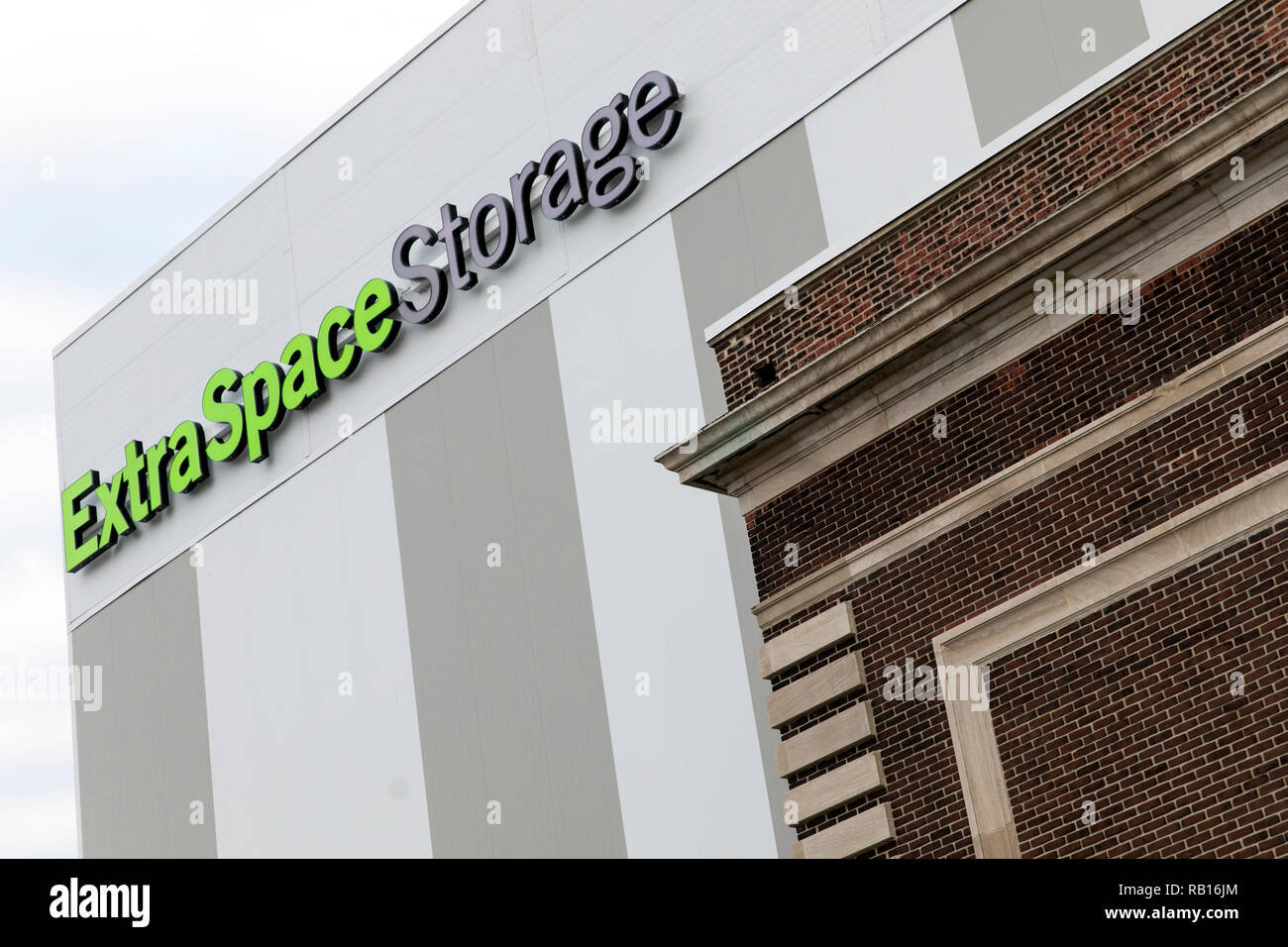 A logo sign outside of a facility occupied by Extra Space Storage in ...