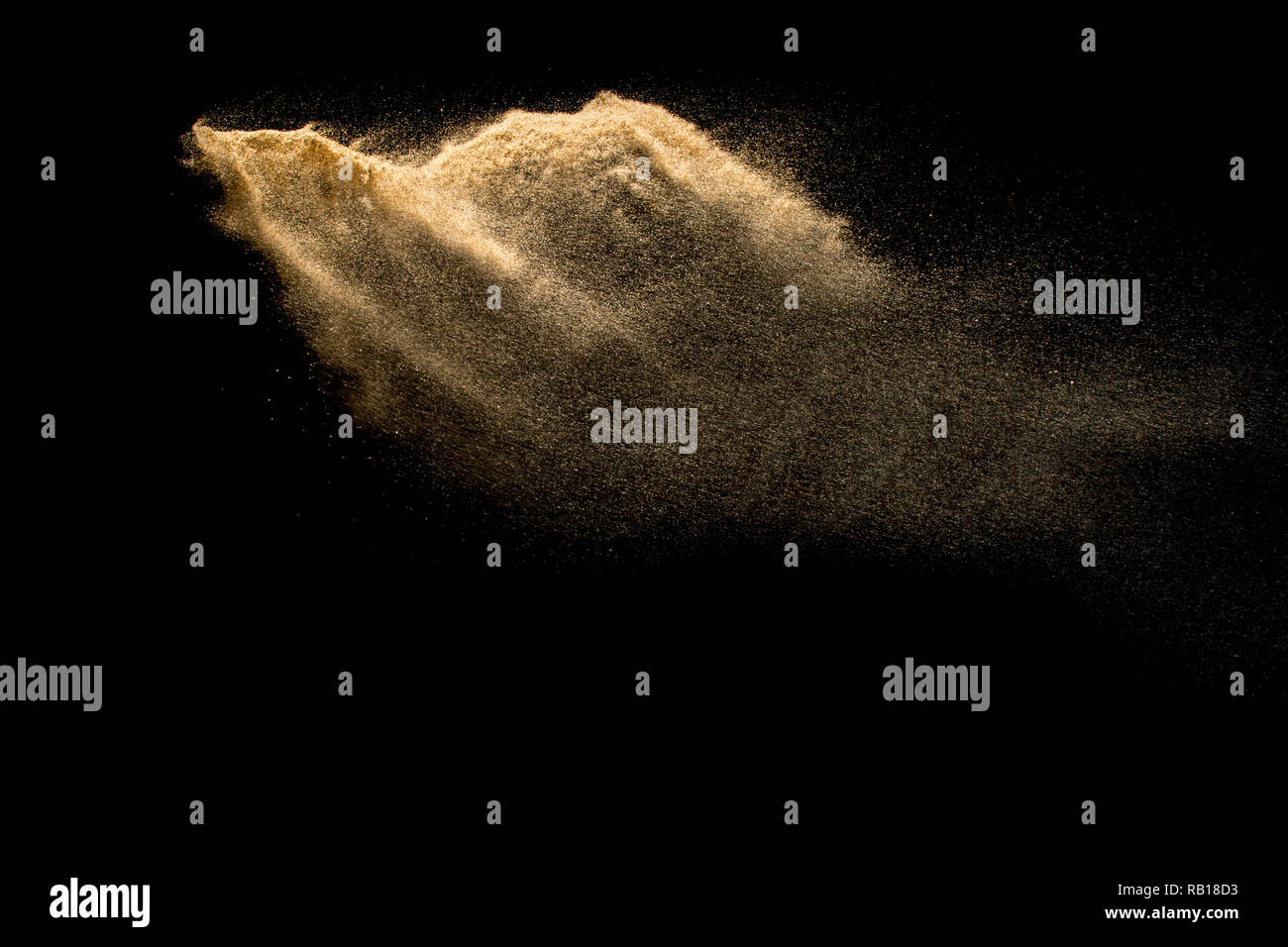 Golden sand explosion isolated on black background. Abstract sand cloud ...