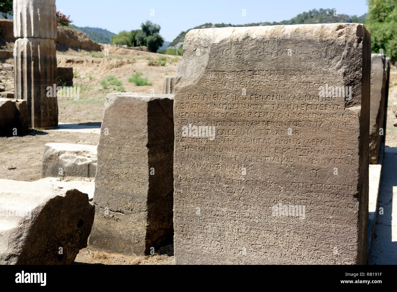 Ancient Greek inscriptions cover a stone pillar monumen at the Propylon ...