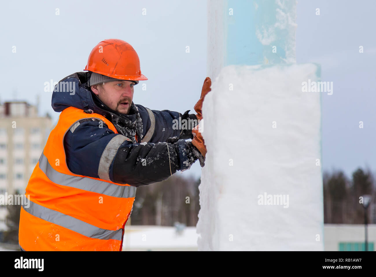 The installer at the construction site of the ice town covers the ...