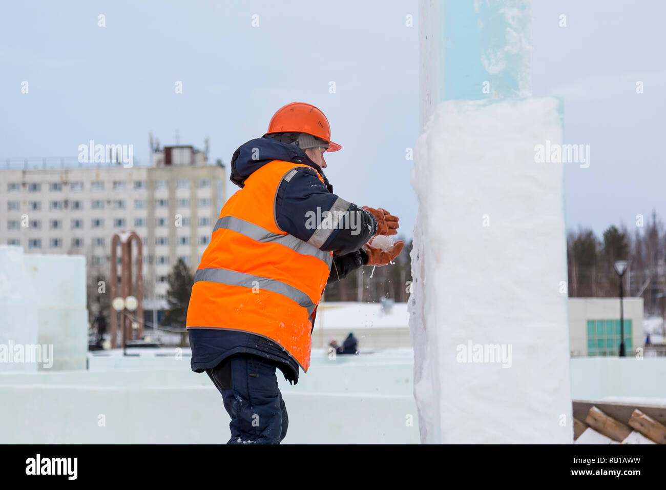 The installer at the construction site of the ice town covers the ...