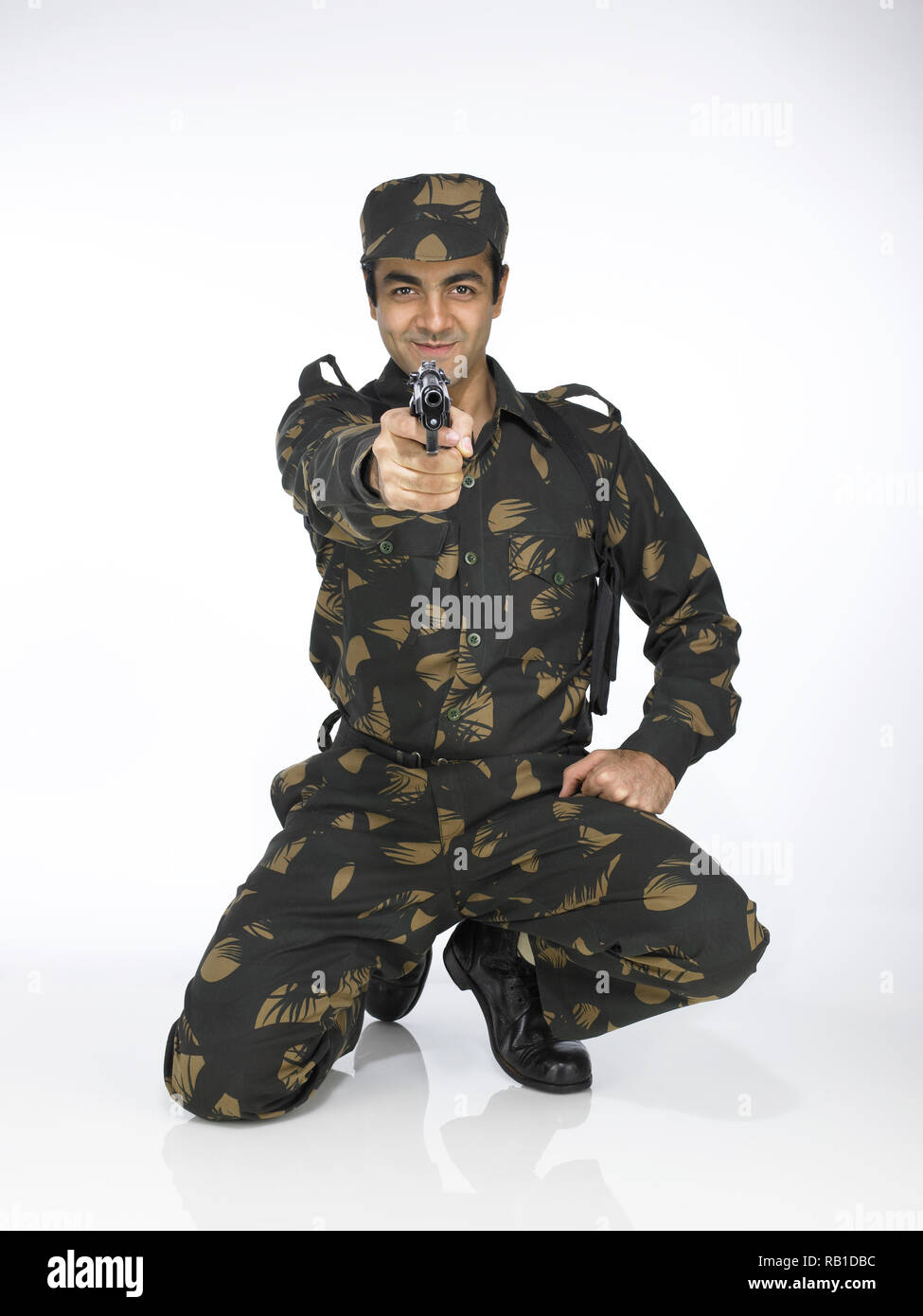 PORTRAIT OF INDIAN SOLDIER DRESSED IN UNIFORM HOLDING A HAND GUN Stock ...