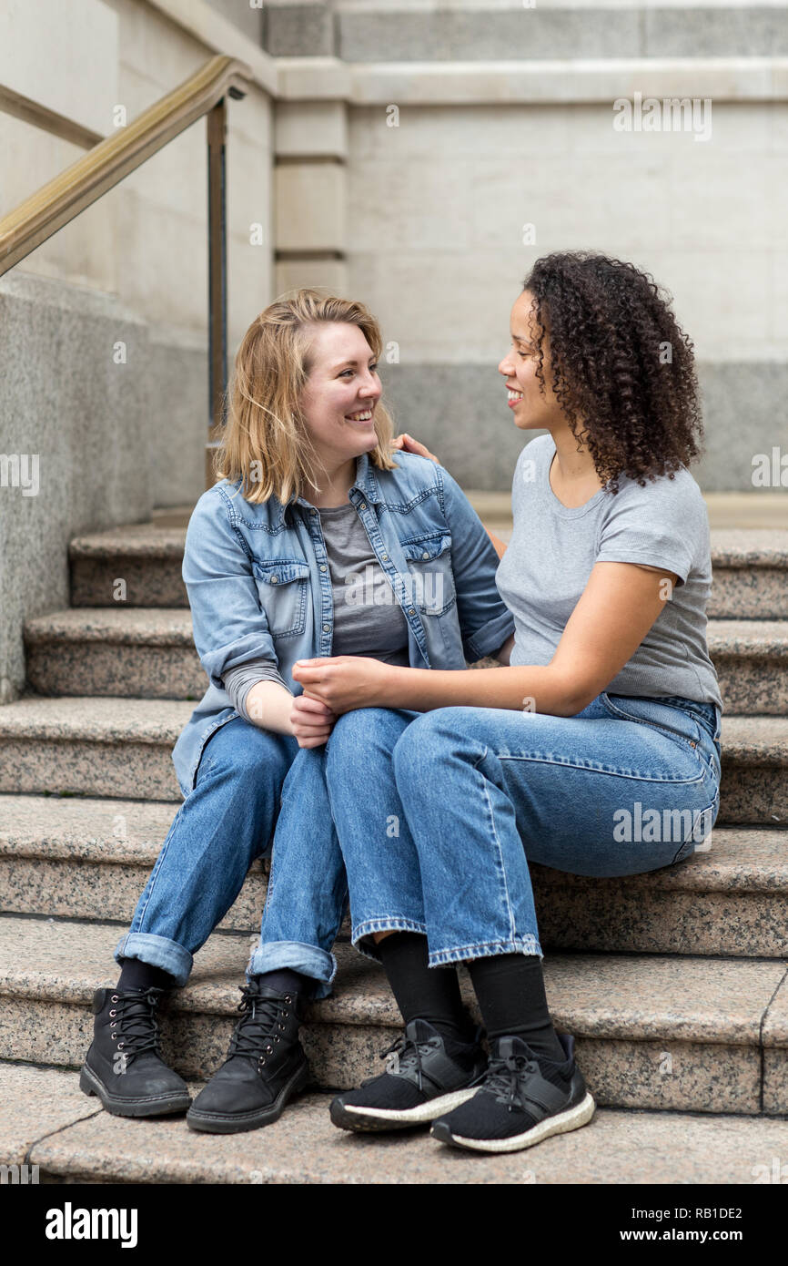 appy lesbian couple sitting together talking Stock Photo - Alamy