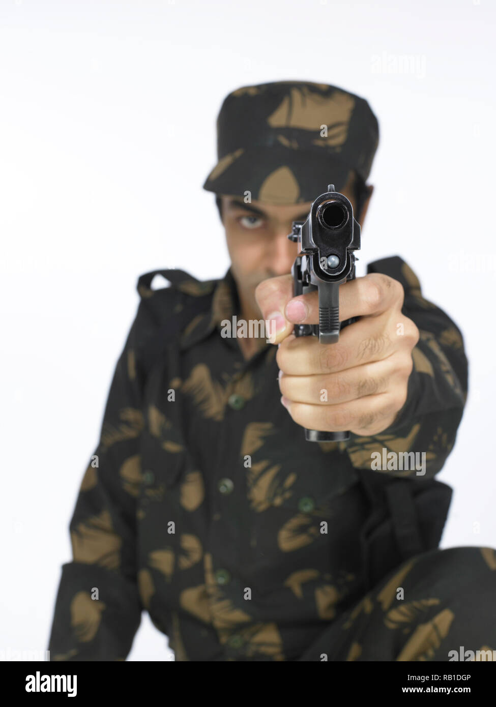PORTRAIT OF INDIAN SOLDIER DRESSED IN UNIFORM HOLDING A HAND GUN Stock ...