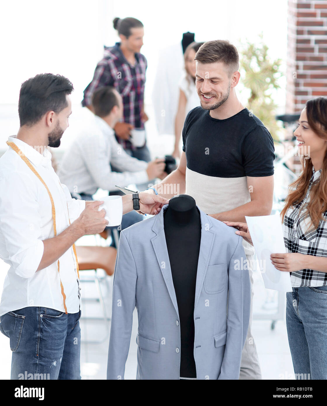 Group of fashion designers discussing designs in a studio Stock Photo ...