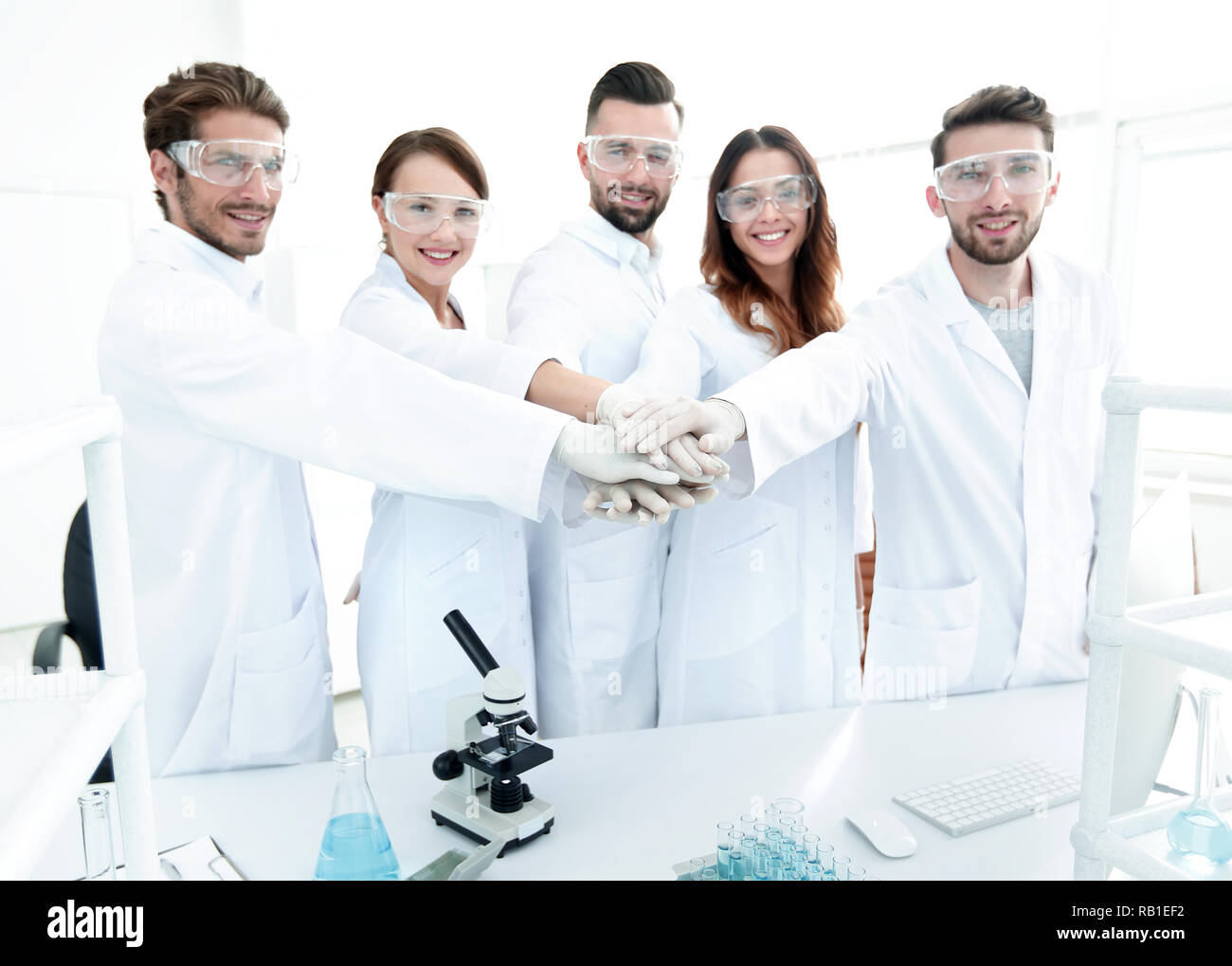successful team of young scientists with hands clasped together Stock ...