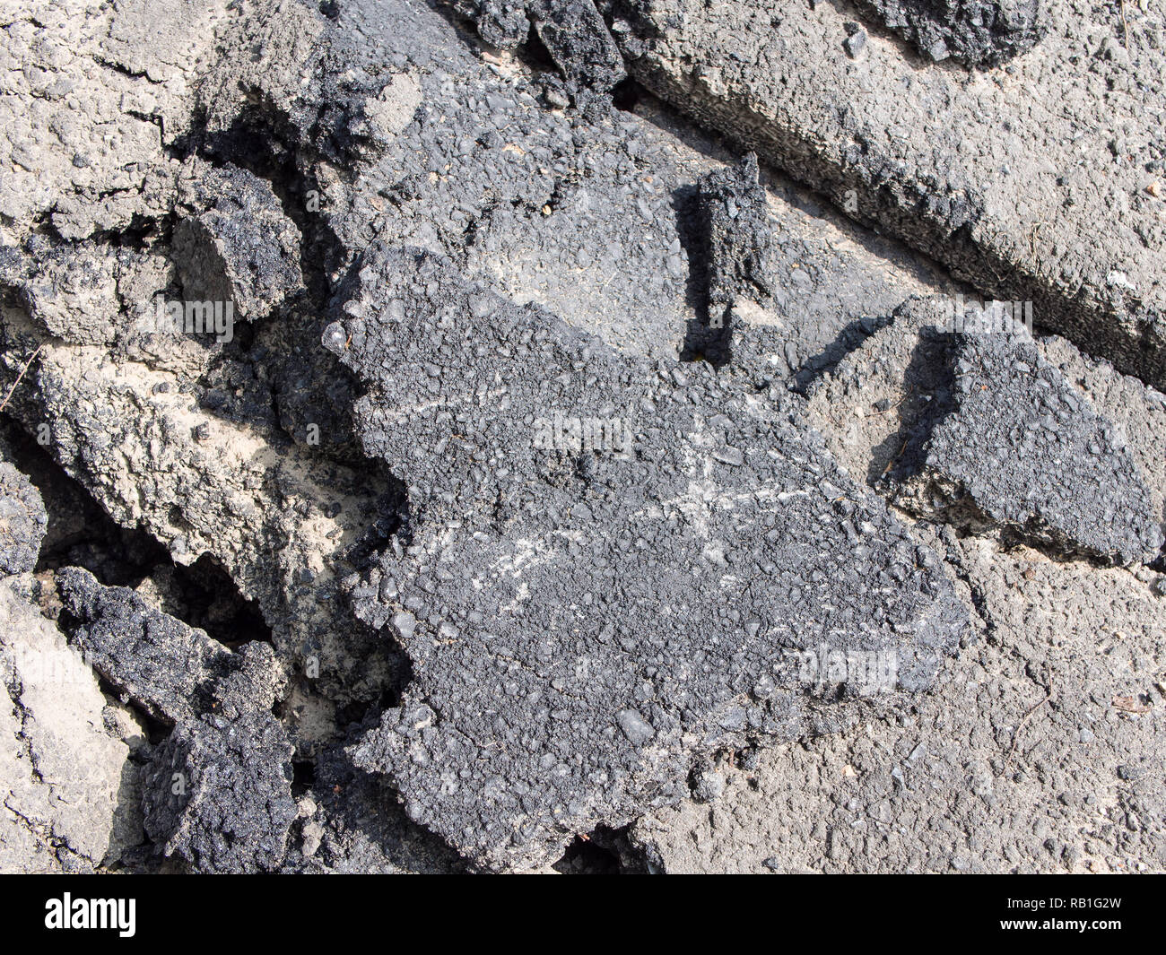 Asphalt Broken Into Pieces In The Summer Sun Stock Photo - Alamy
