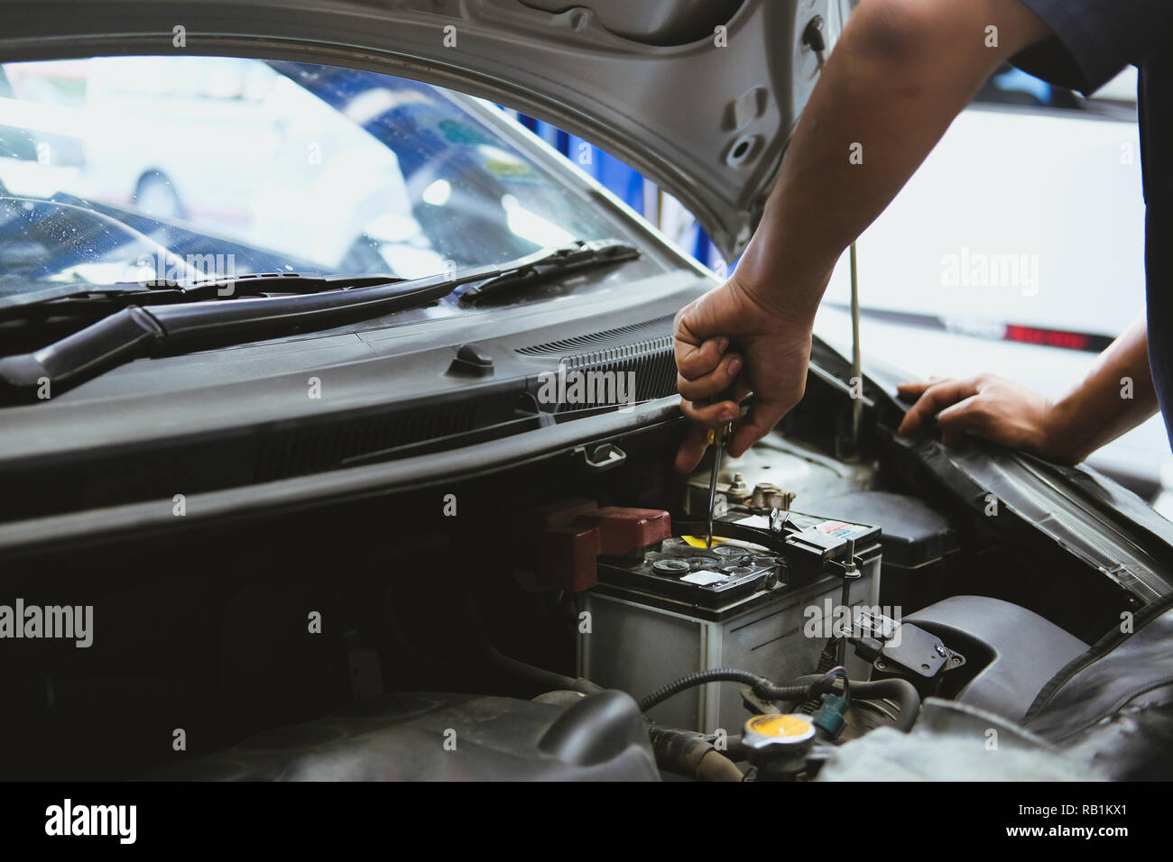mechanic opening closing checking car battery in automobile repair ...
