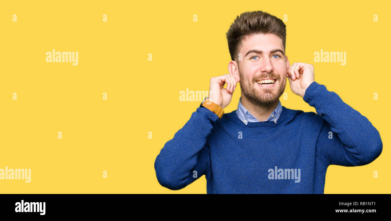 Young handsome bussines man Smiling pulling ears with fingers, funny ...