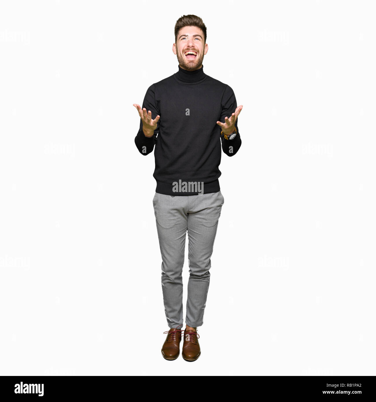 Young handsome blond man wearing winter sweater crazy and mad shouting ...