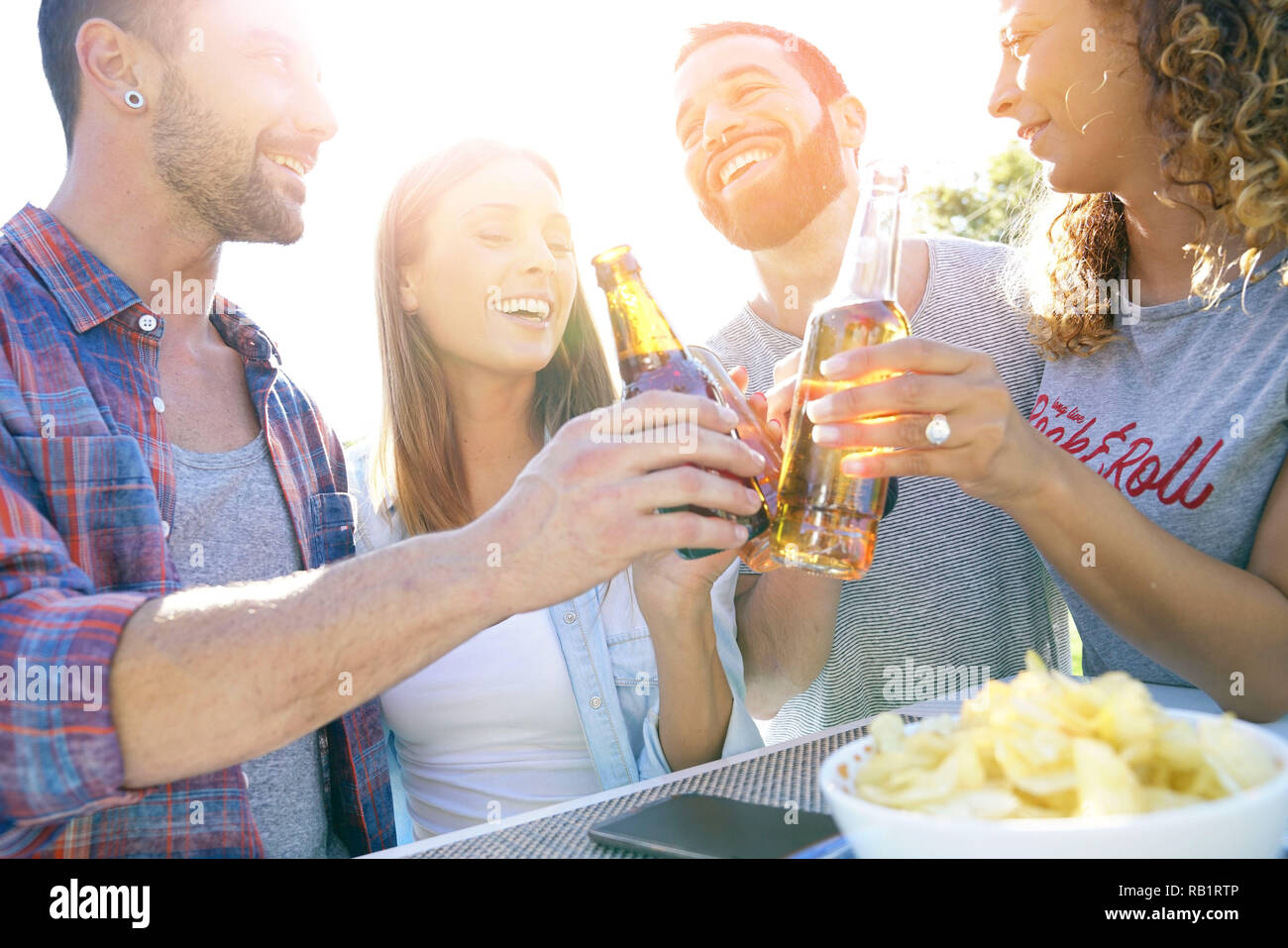 Group of friends cheering with beers Stock Photo - Alamy