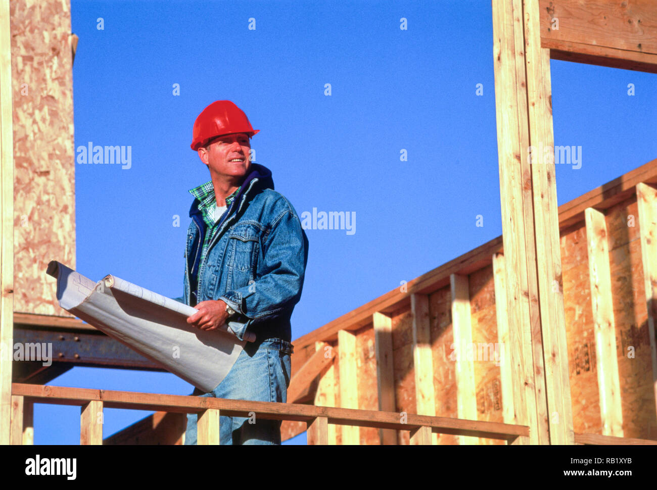 Man with Plans oversees Home Construction in a suburban neighborhood ...