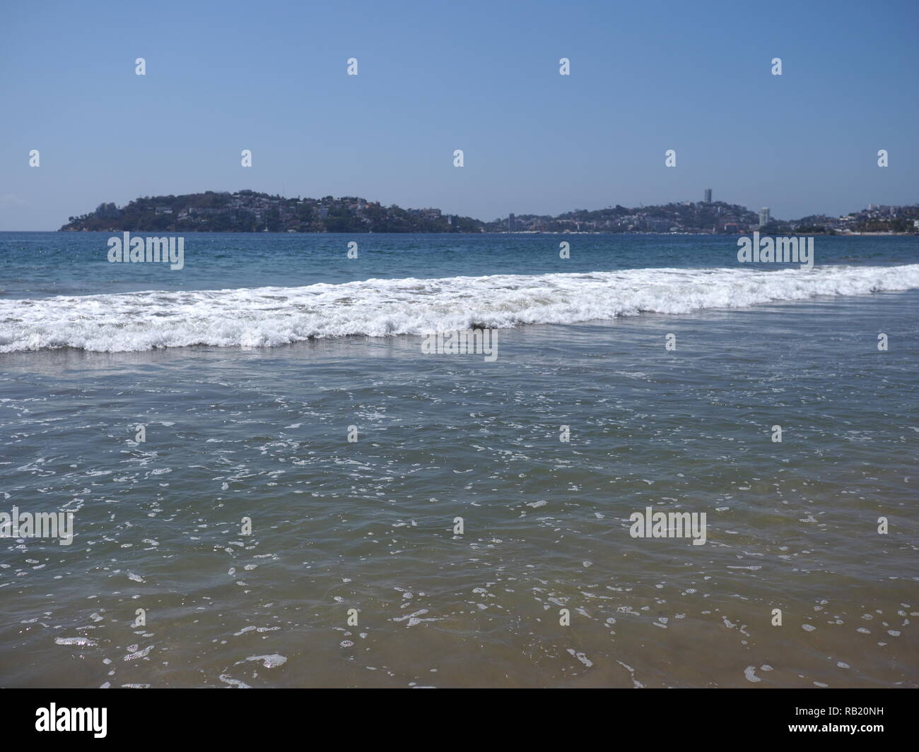 Scenery of calm beach at bay of ACAPULCO city in Mexico and white waves ...
