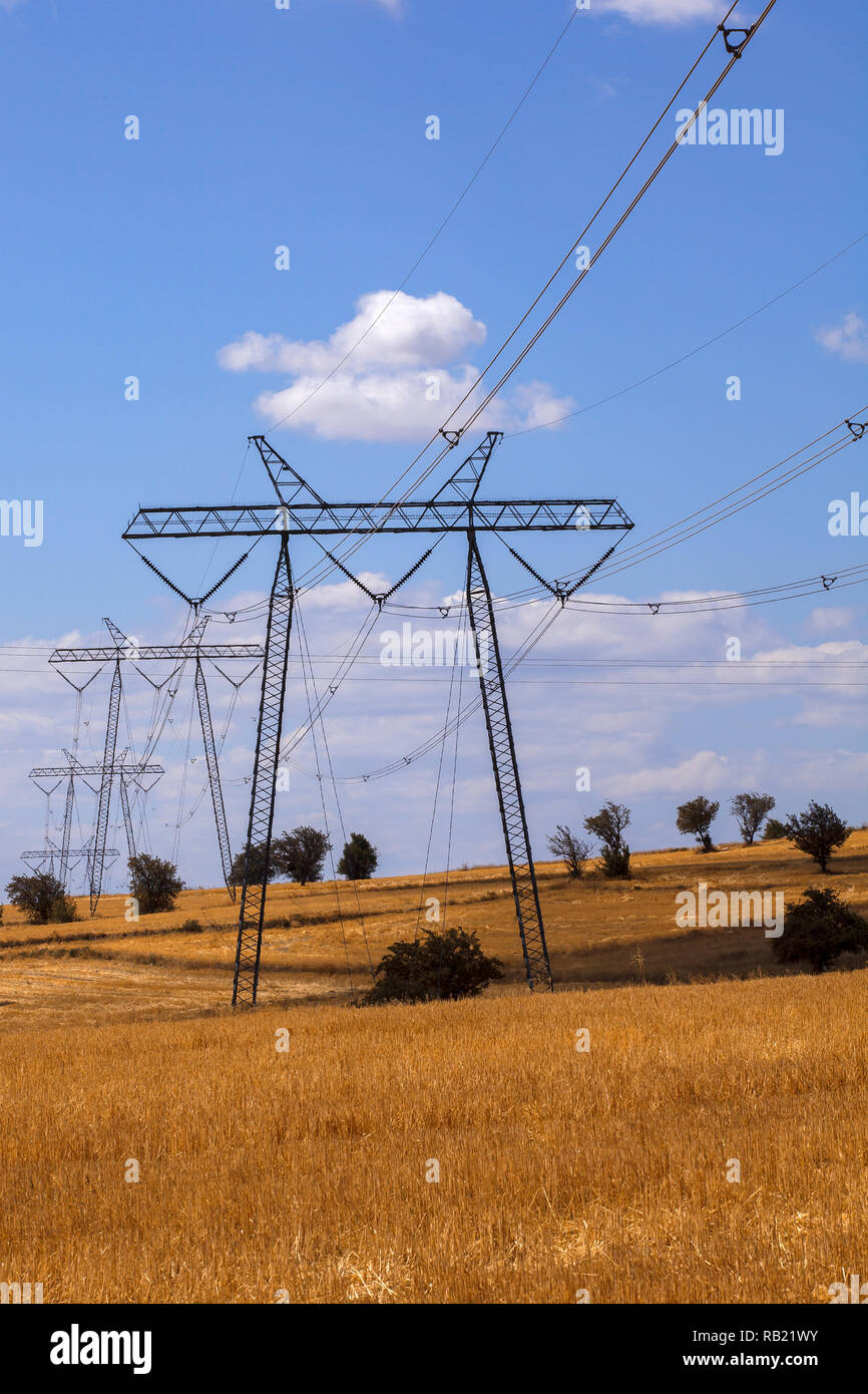Electricity pylons and overhead cables receding through countryside ...