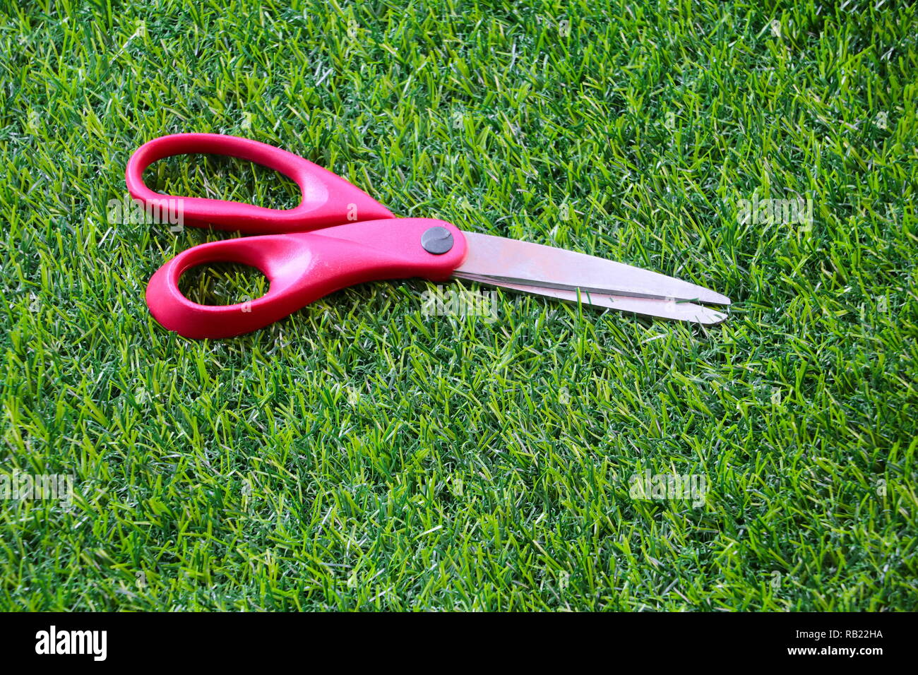 scissor red on artificial grass background Stock Photo - Alamy