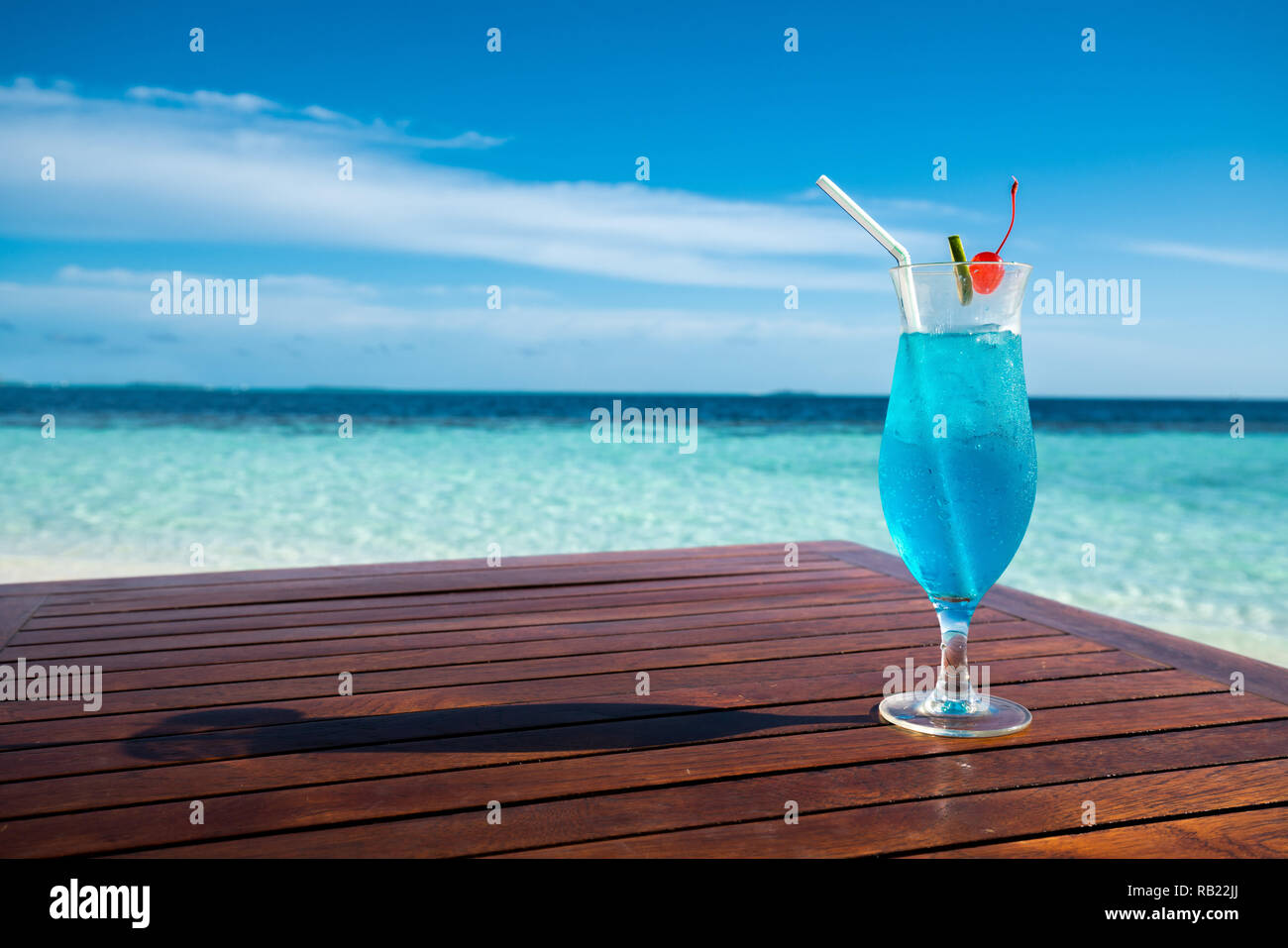 Blue lagoon cocktail on table and beautiful sea background Stock Photo ...