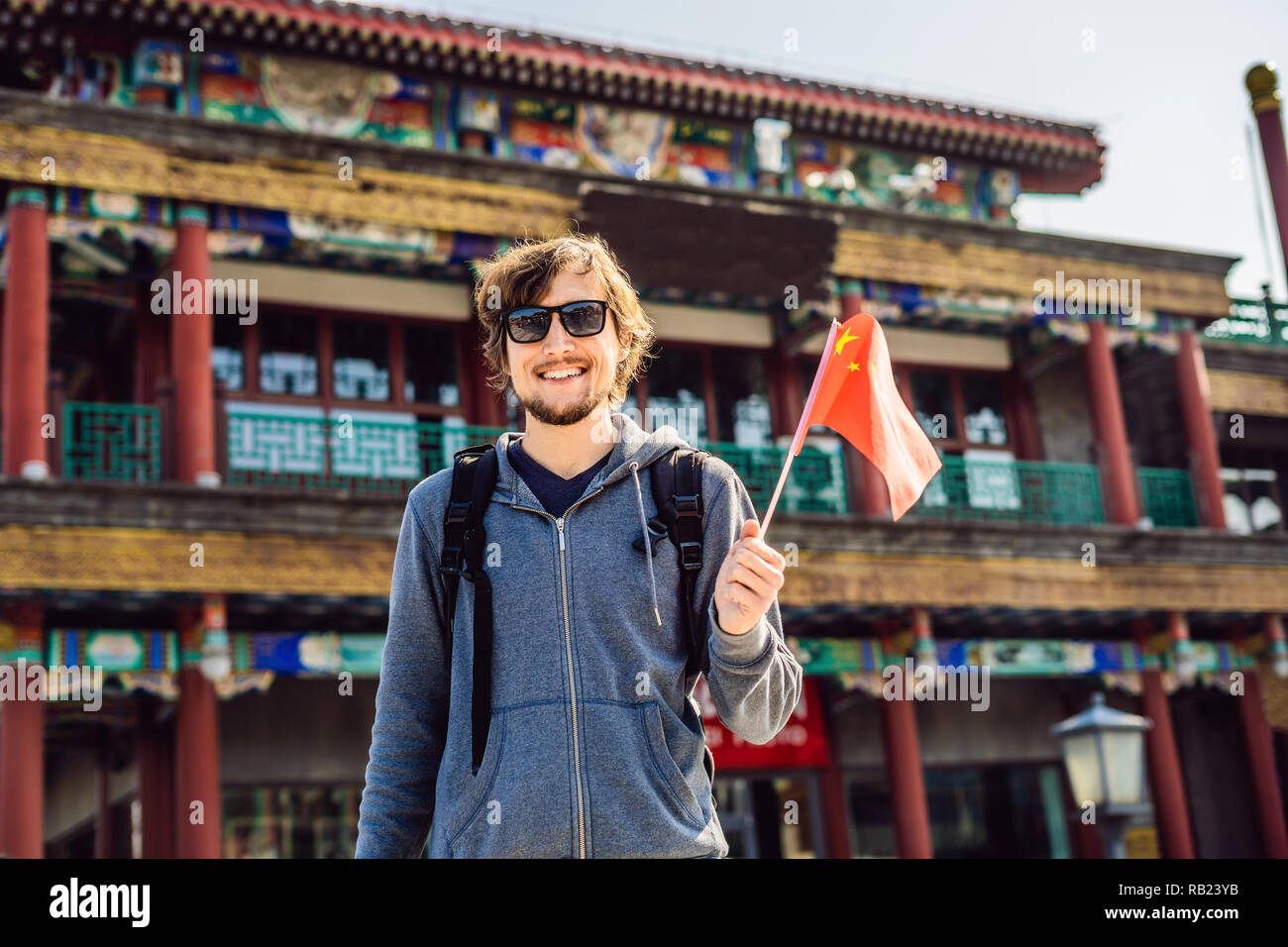 Enjoying vacation in China. Young man with national chinese flag on the ...