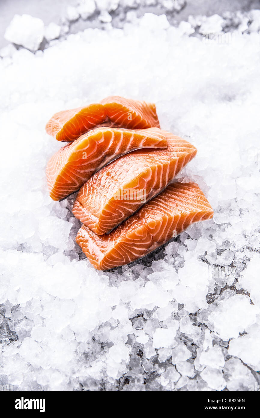 Salmon fillets portioned on ice and empty kitchen board Stock Photo - Alamy