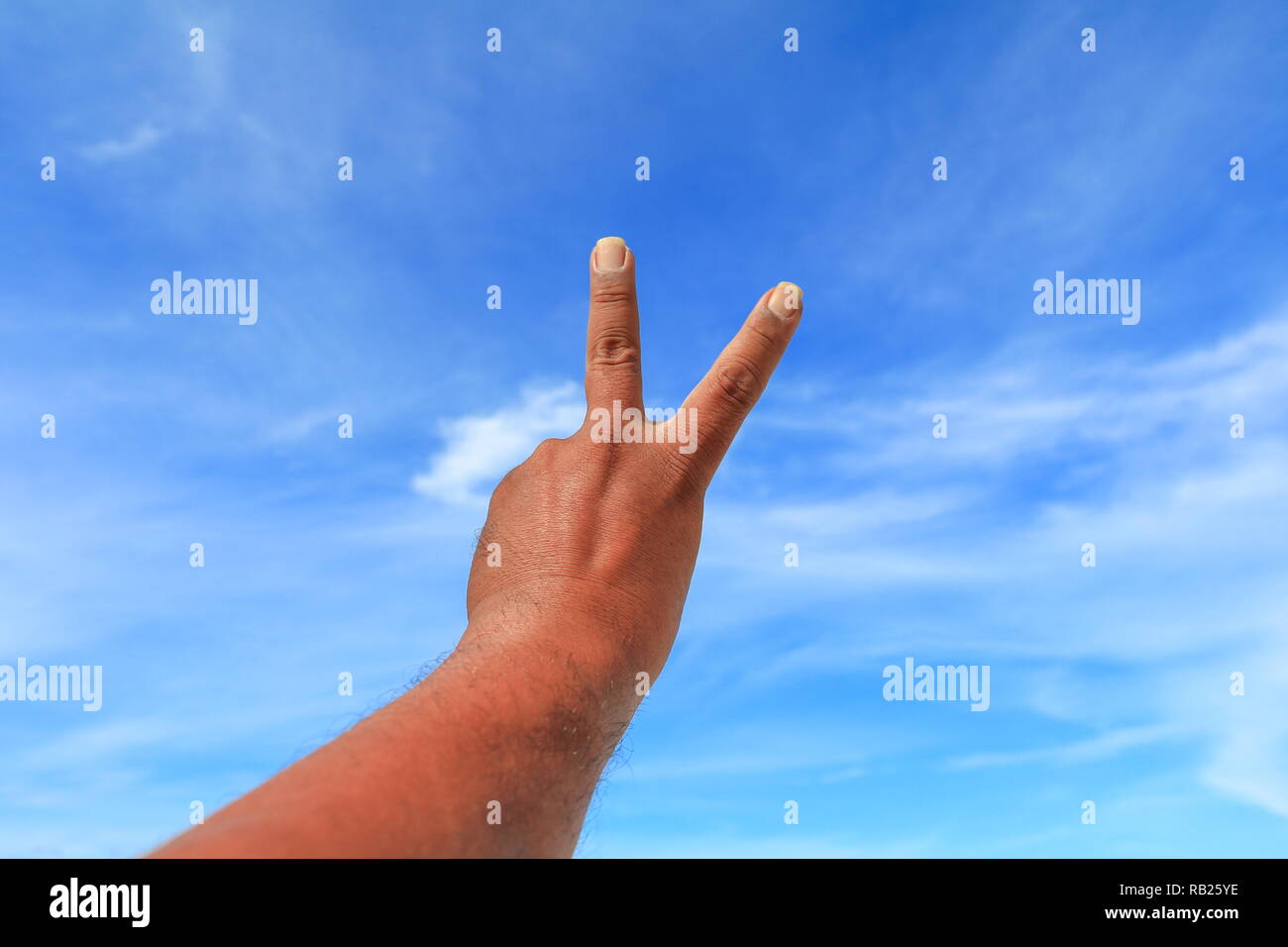 hand show counting number two on sky background Stock Photo - Alamy