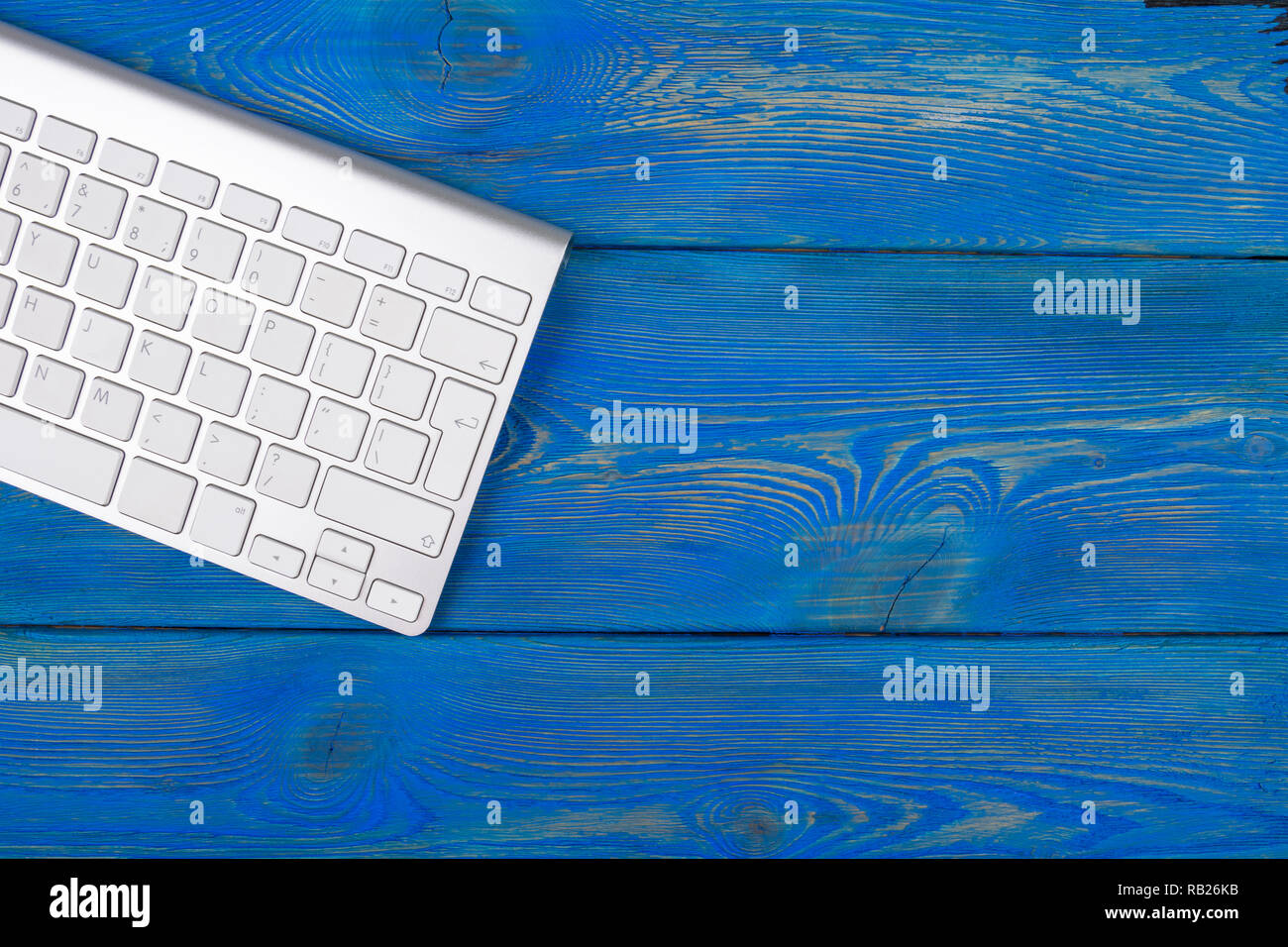 Business workplace with computer, wireless keyboard on old blue wooden ...