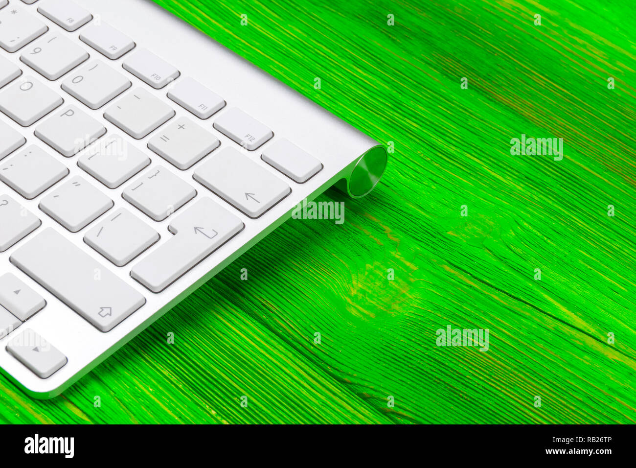 Business workplace with computer, wireless keyboard, keys on old green ...