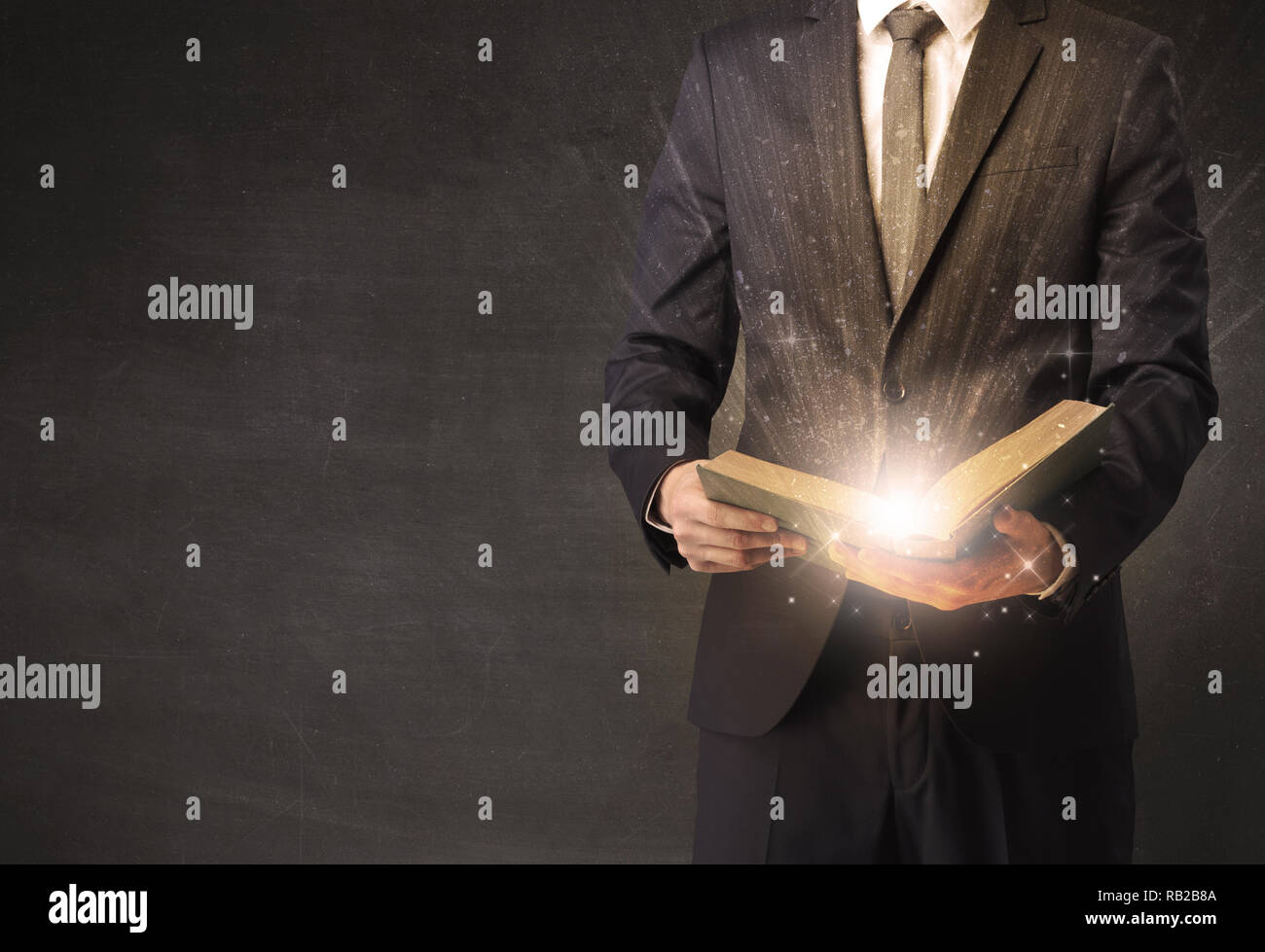 Man holding and reading a shiny book Stock Photo - Alamy